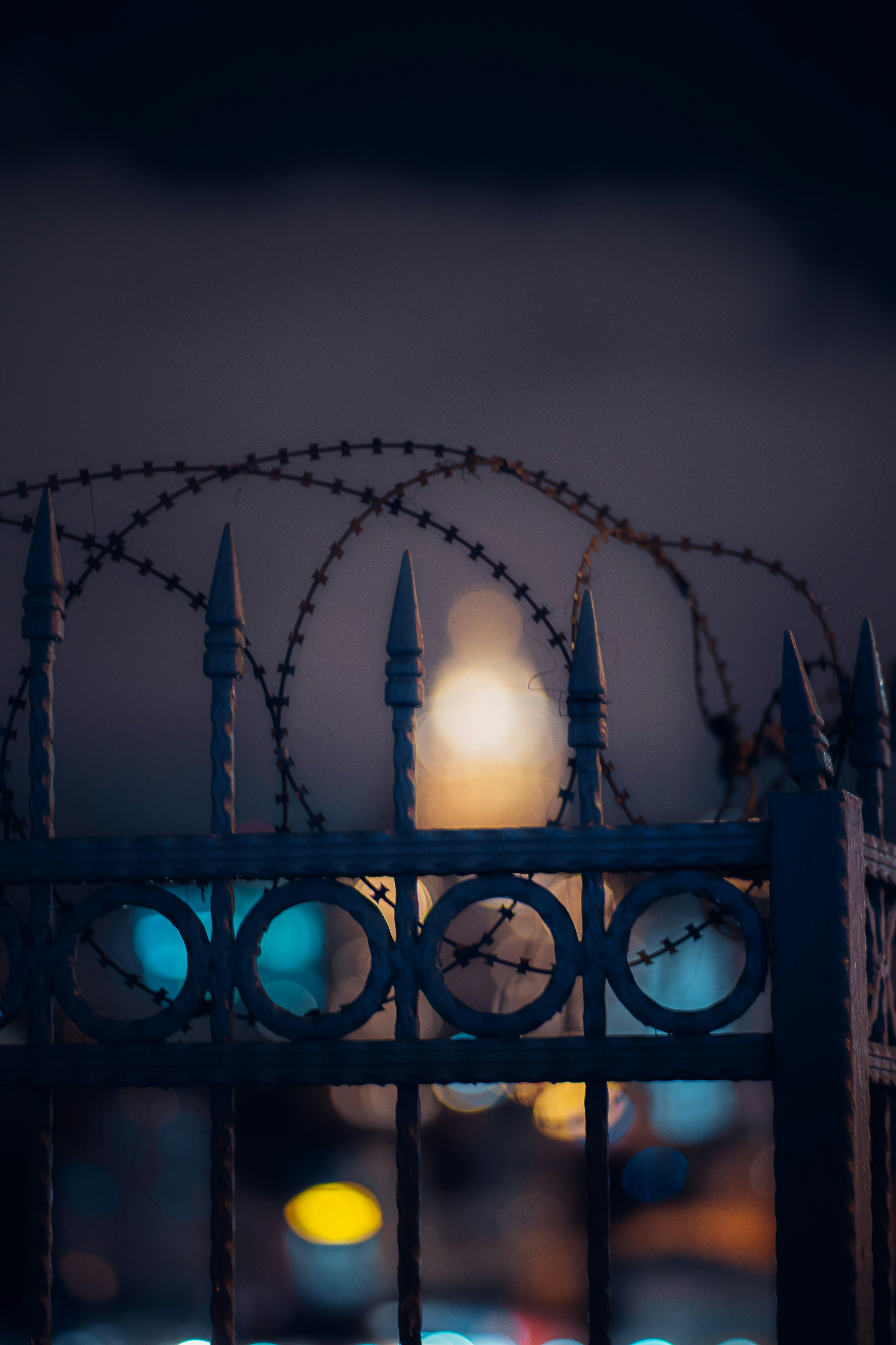 Locked Gate at Night: Barbed Shadows Beyond the Frosted Fences