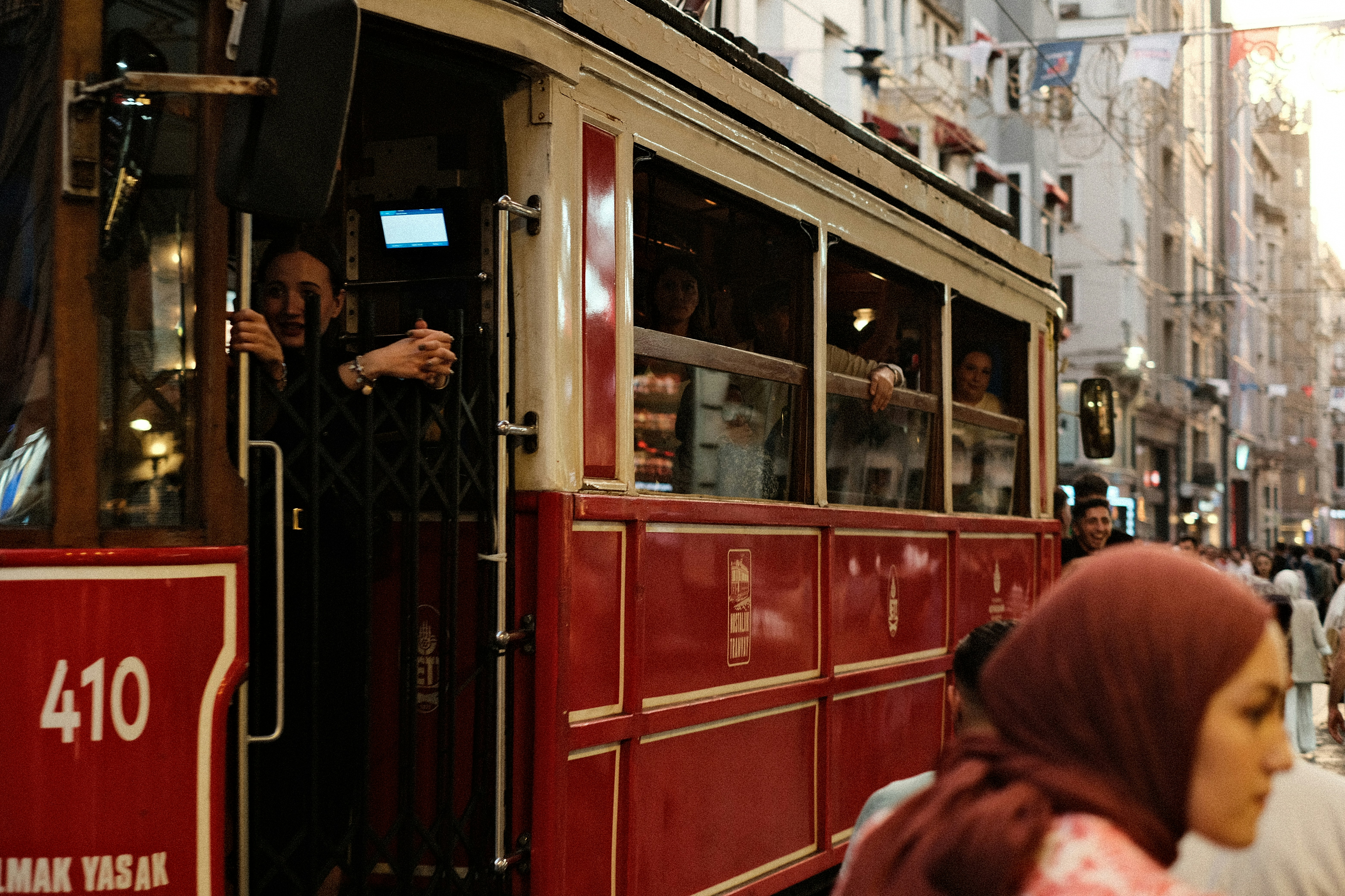 Red Tram Threshold: A Glimpse of City Life Through Glass Doors
