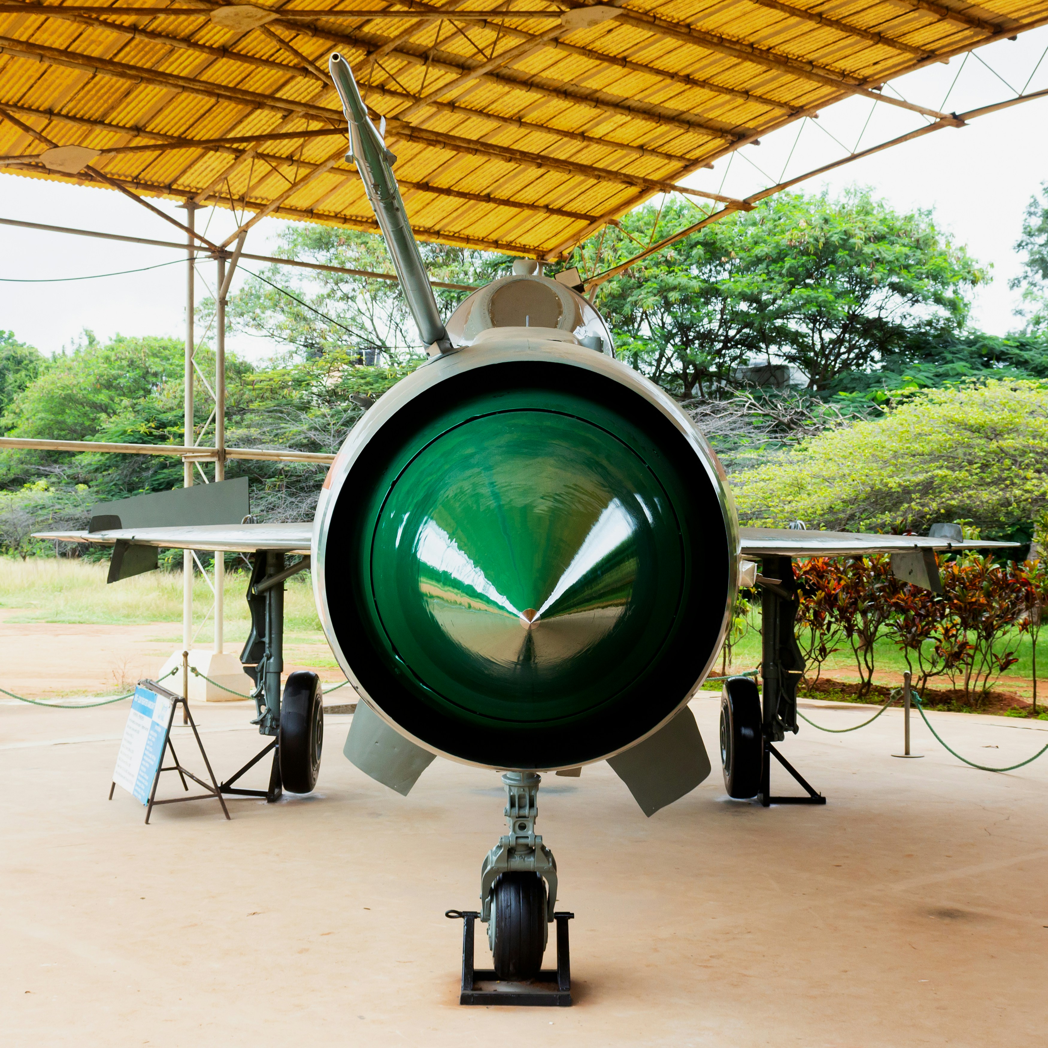 A green jet sitting under a yellow awning photo – Free Airplane Image ...