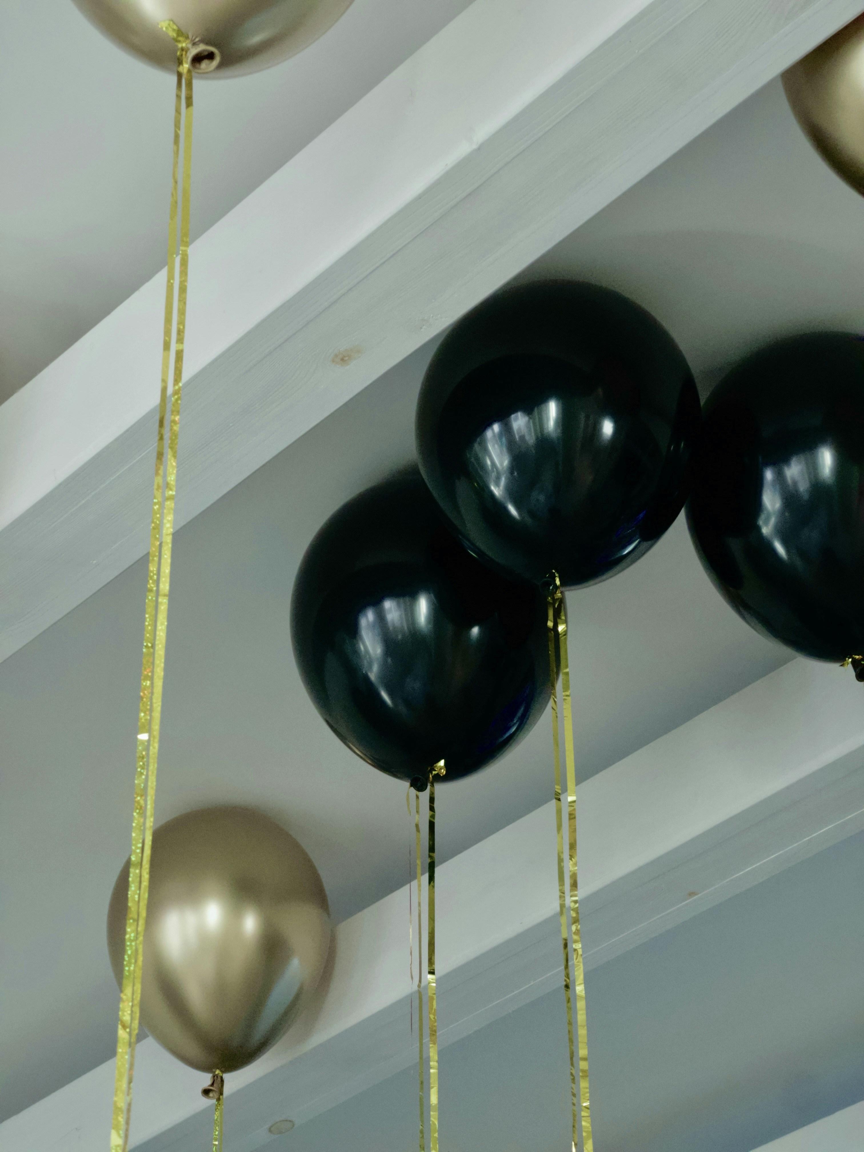 Midnight Bubbles and Gold Threads Against Pale Ceiling Beams