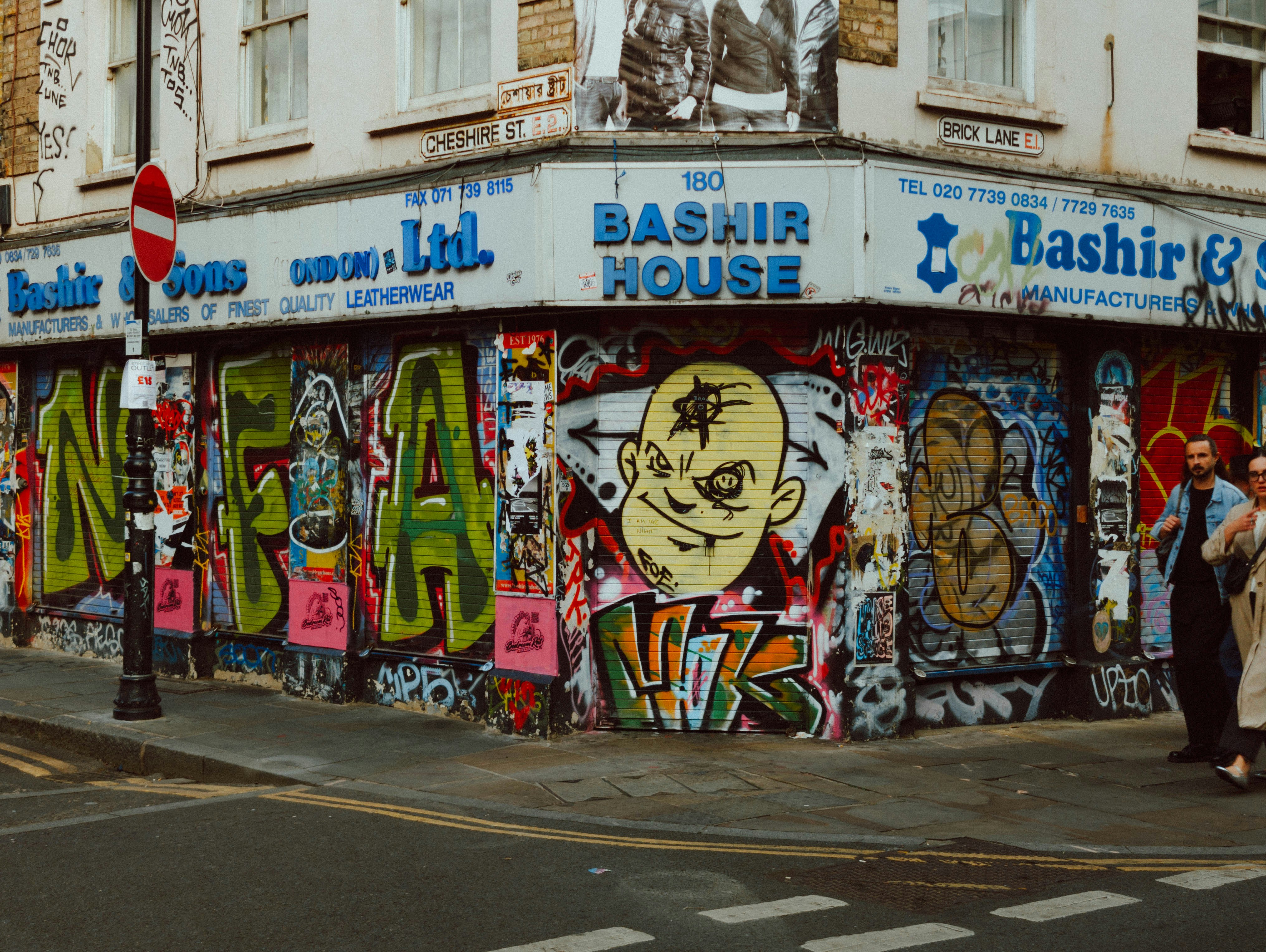 A street corner with a building covered in graffiti photo – Free Art ...