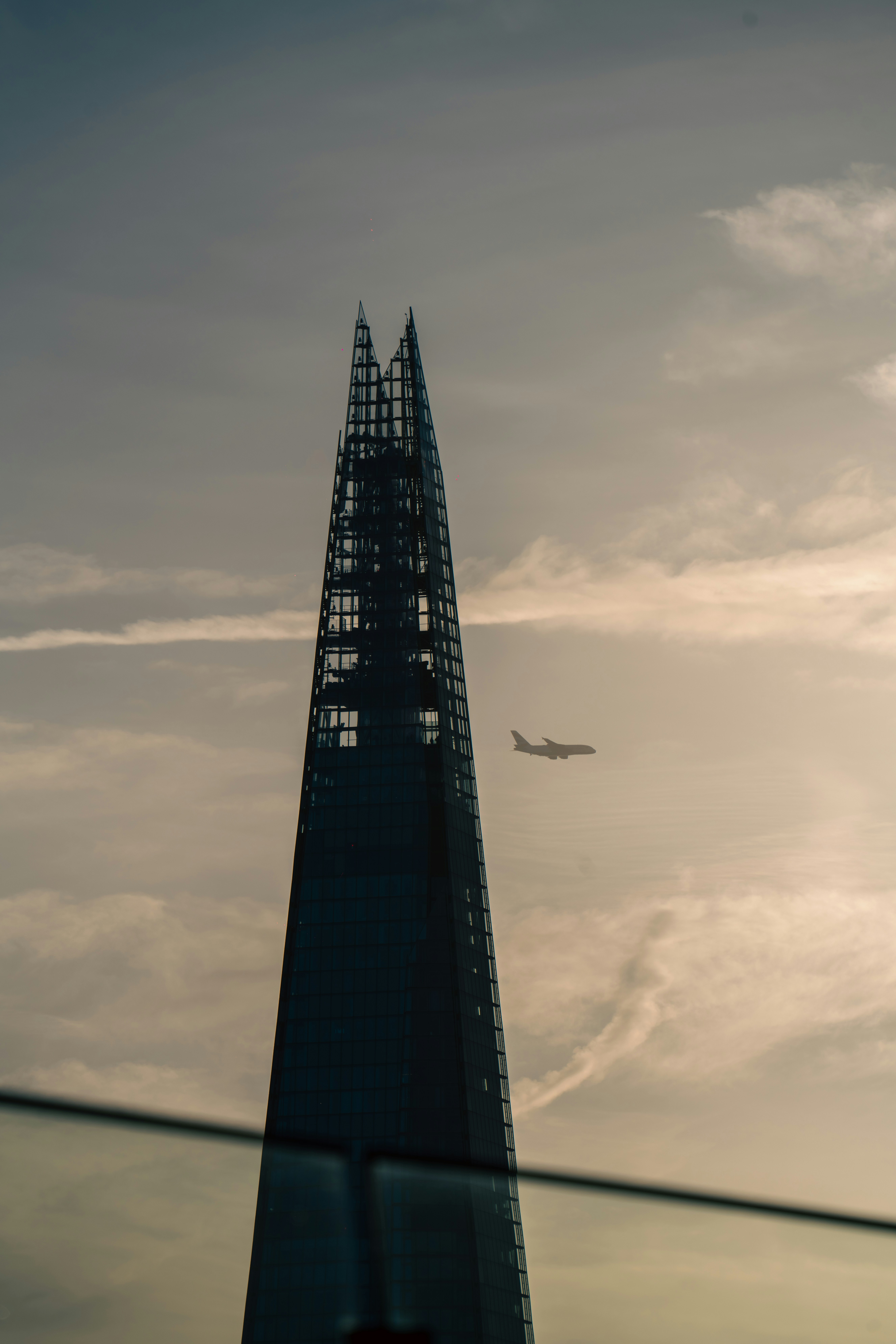 Dusk over The Shard: A Plane Gliding Past the Glass Needle