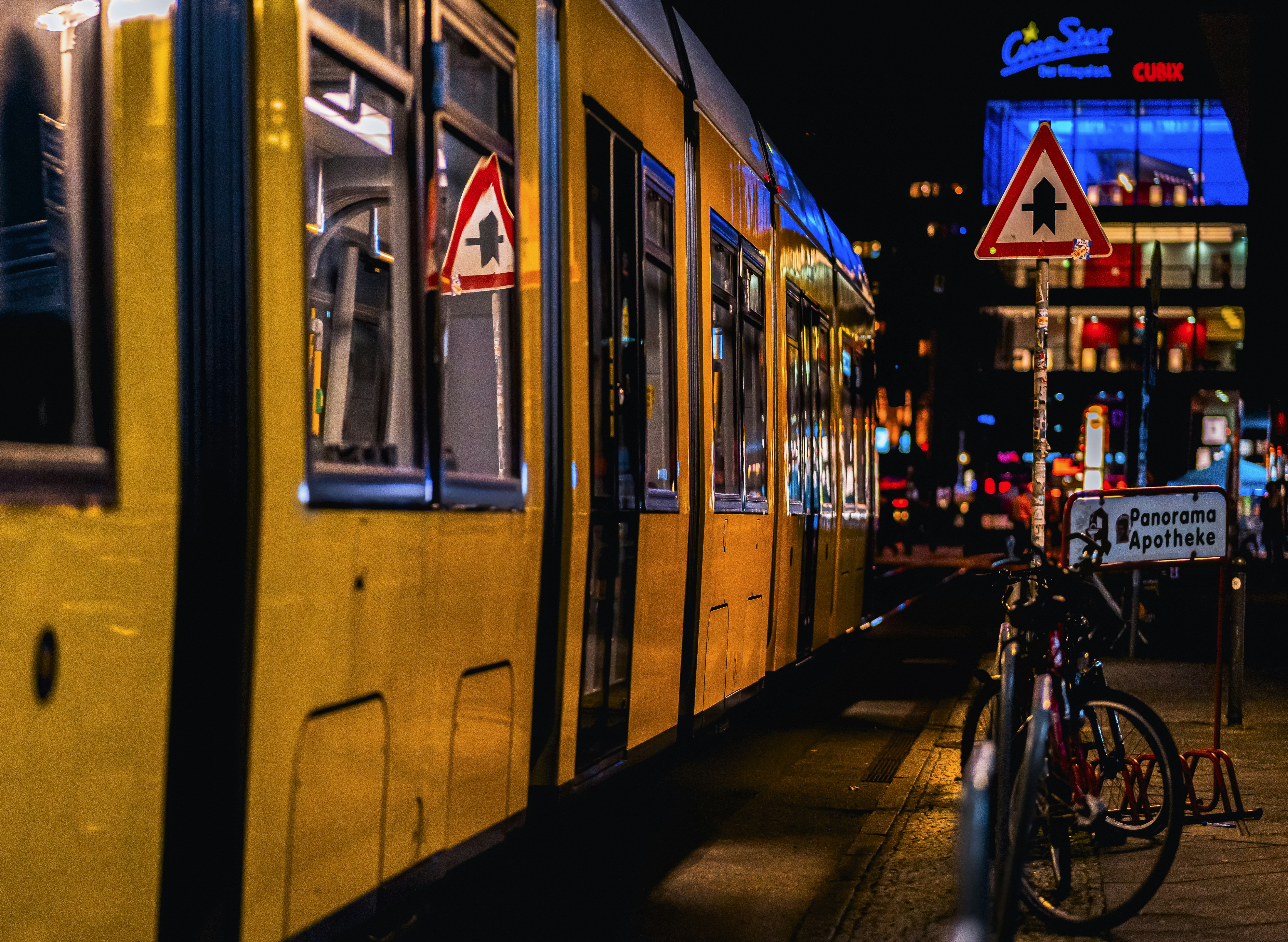 Yellow tram at a neon-lit city corner