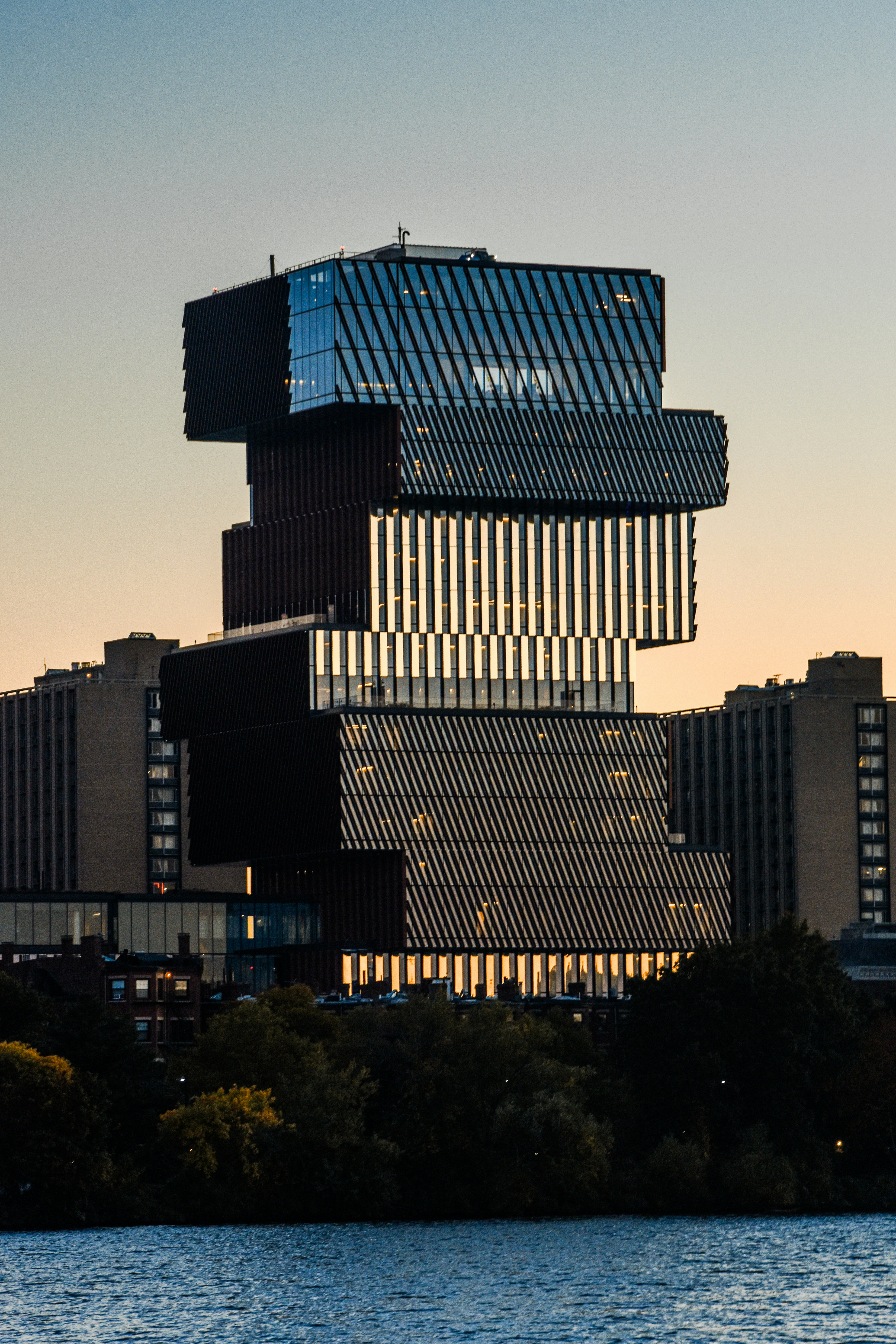 A tall building sitting next to a body of water photo – Free Building ...