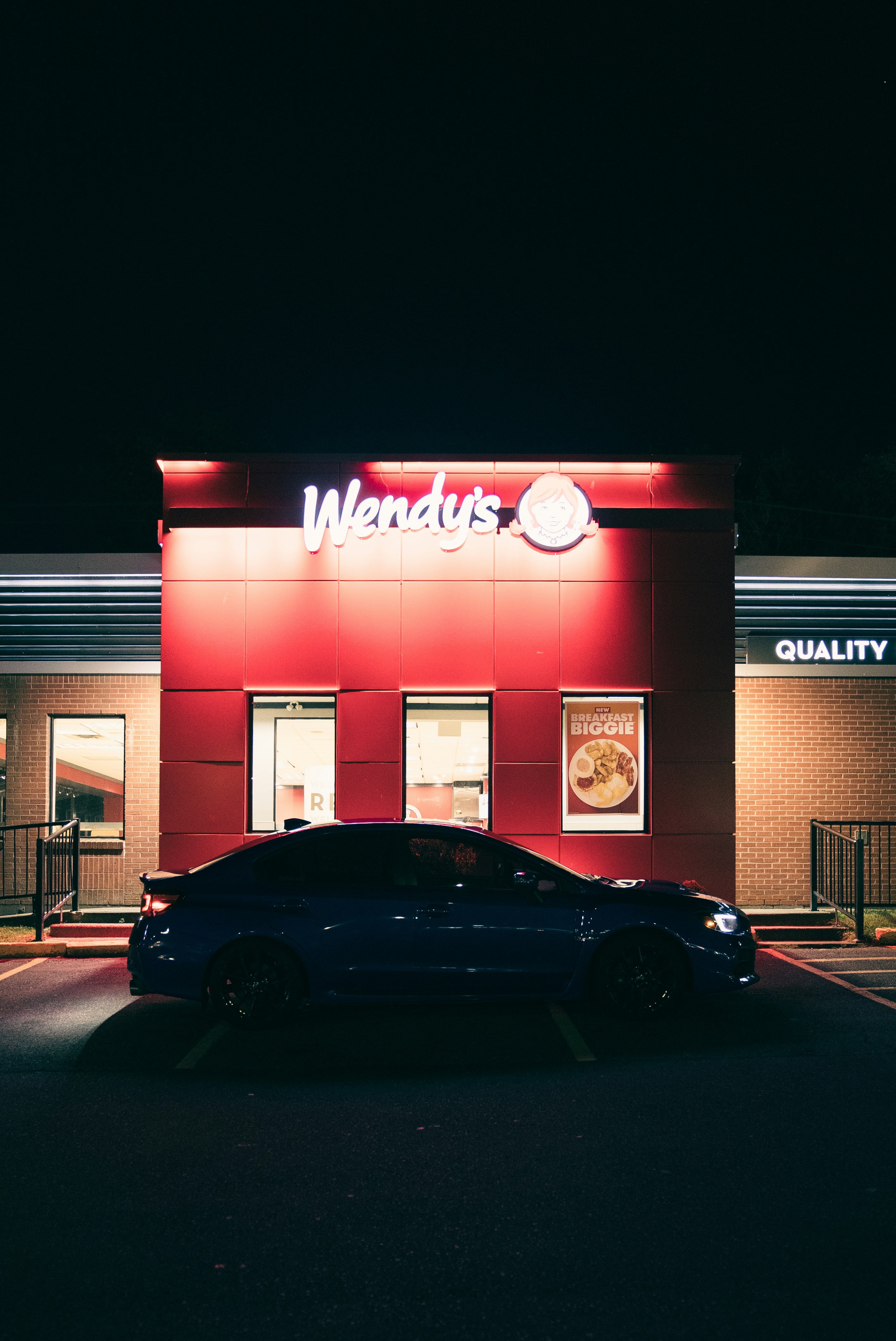 A car parked in front of a restaurant at night photo – Free Alloy wheel ...