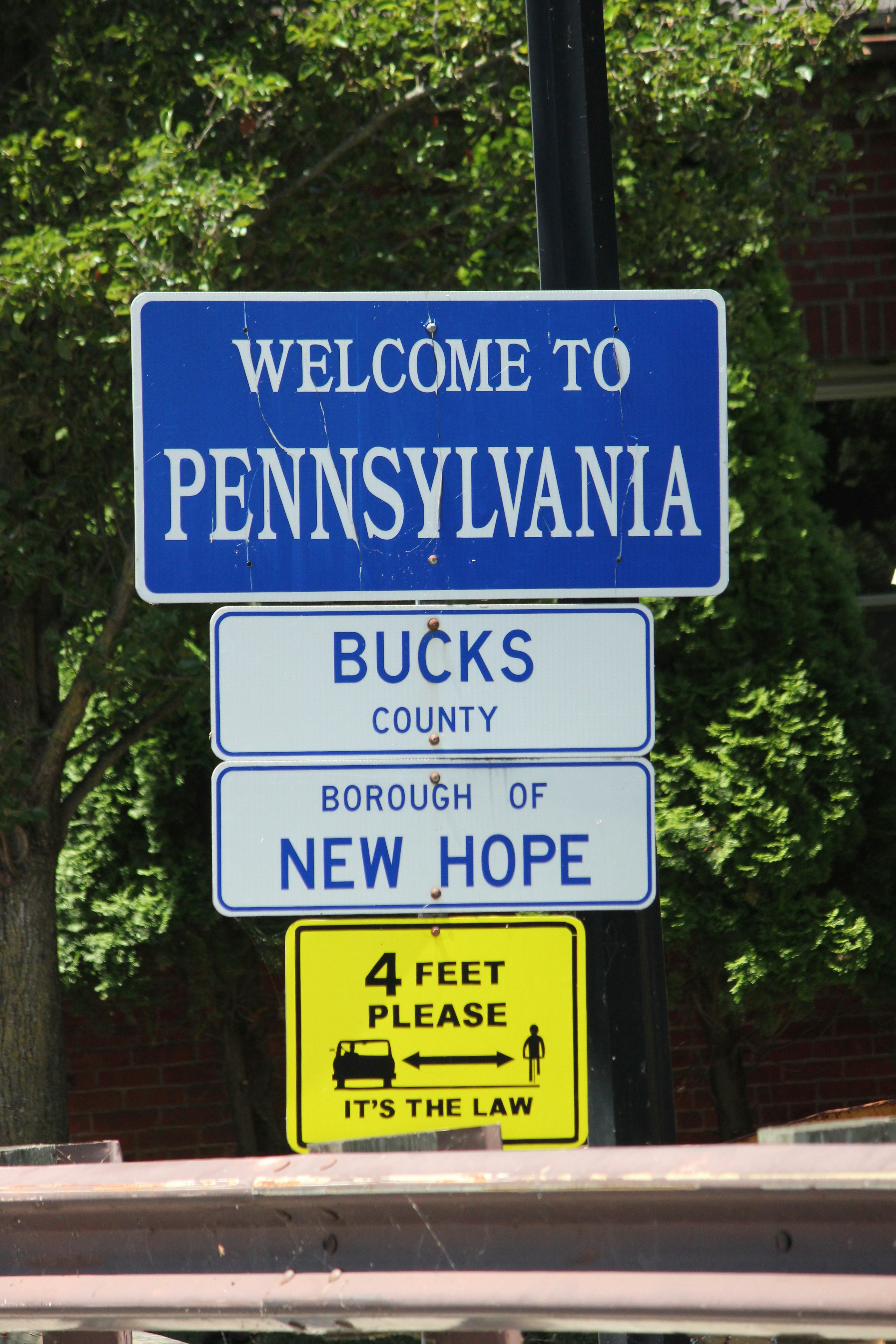 A blue and white street sign sitting on the side of a road photo – Free ...