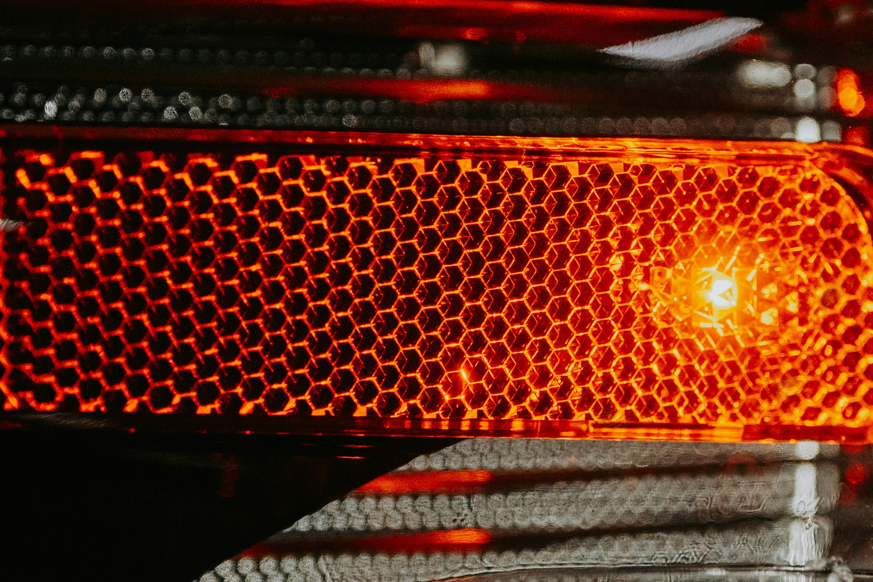 Orange glow in a mesh of light: automotive tail lamp close-up
