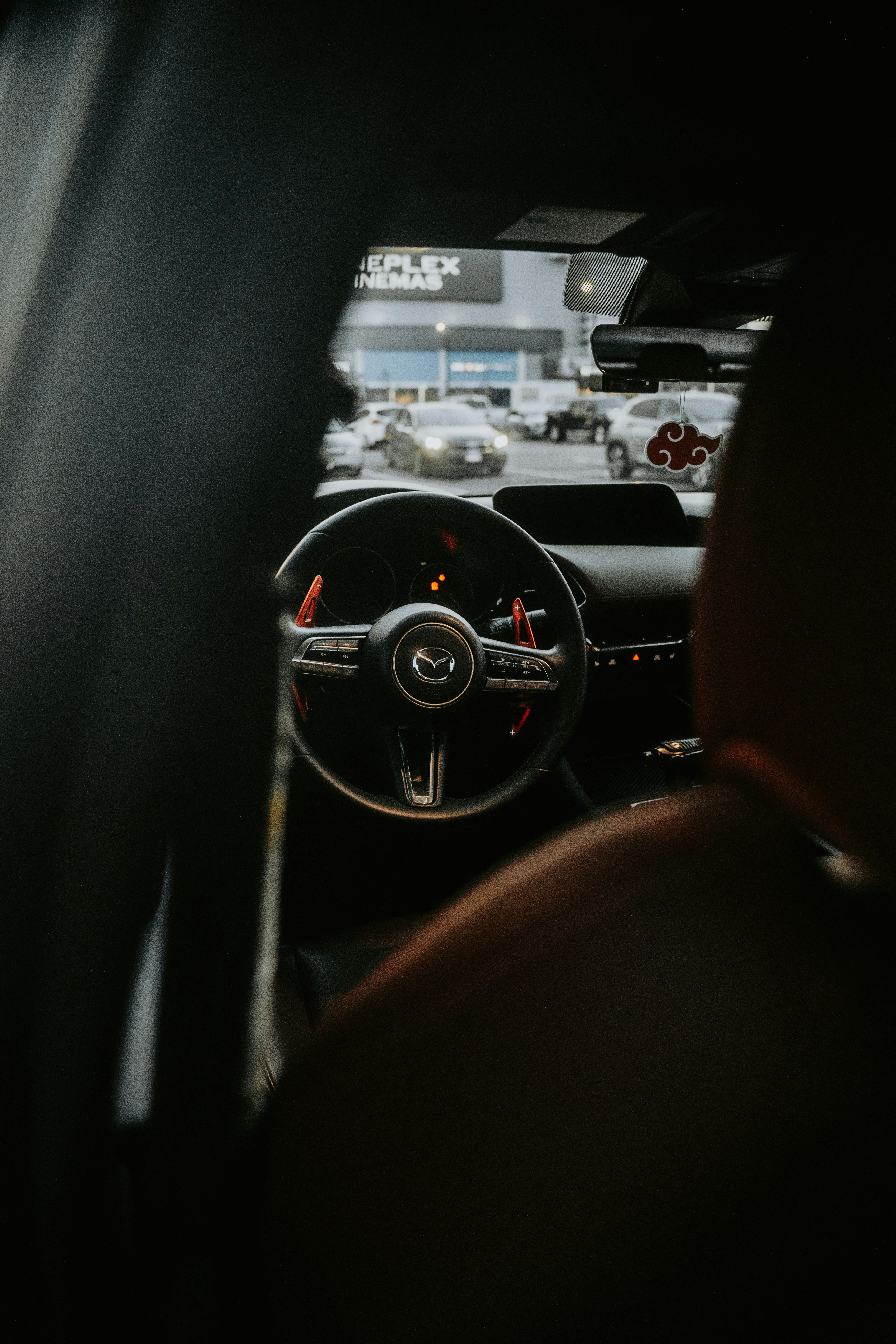 Steering in Focus: Mazda emblem and cockpit glow inside a taxi