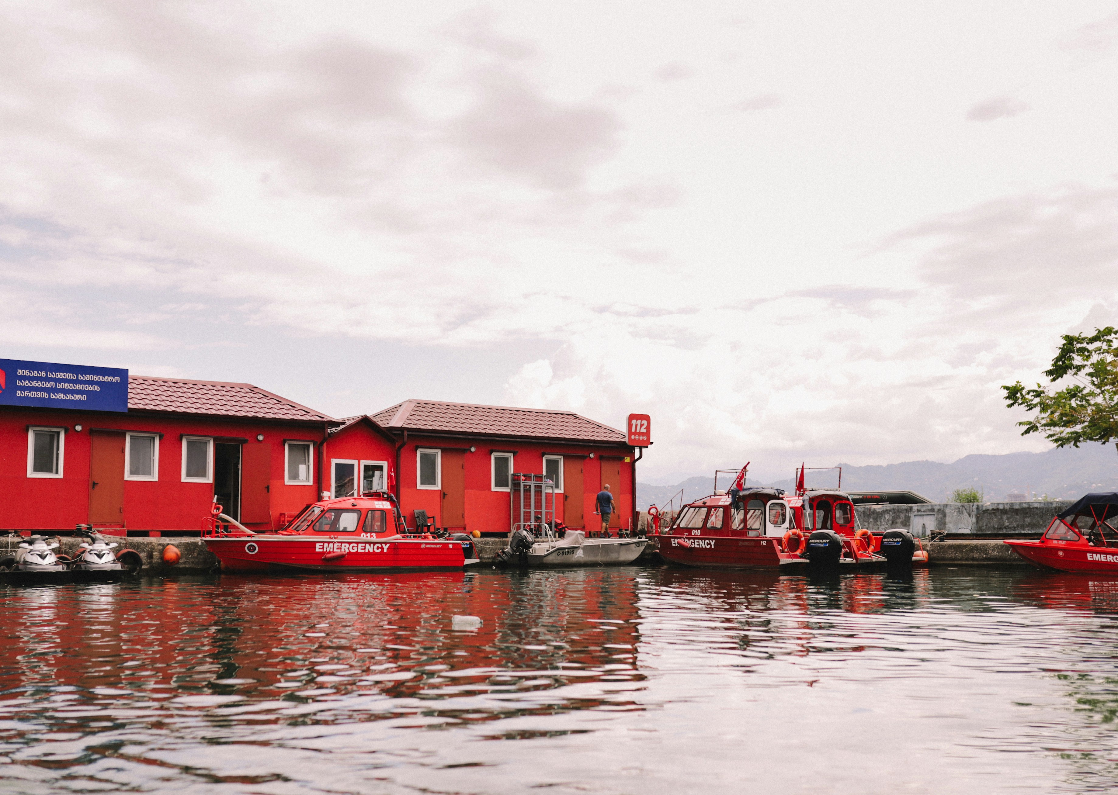 A row of red houses sitting next to a body of water photo – Free Sea ...
