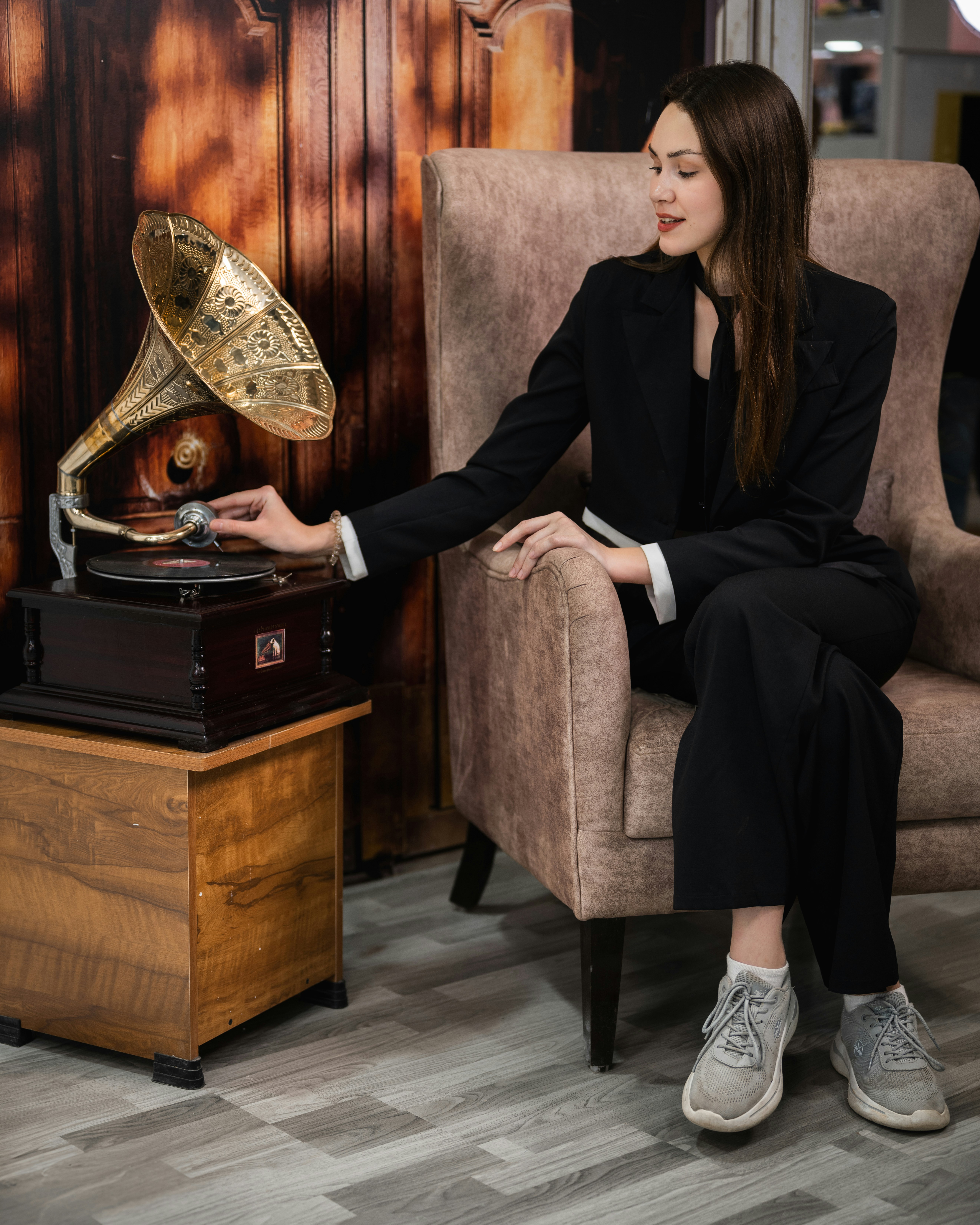 A woman sitting in a chair next to a record player photo – Free ...