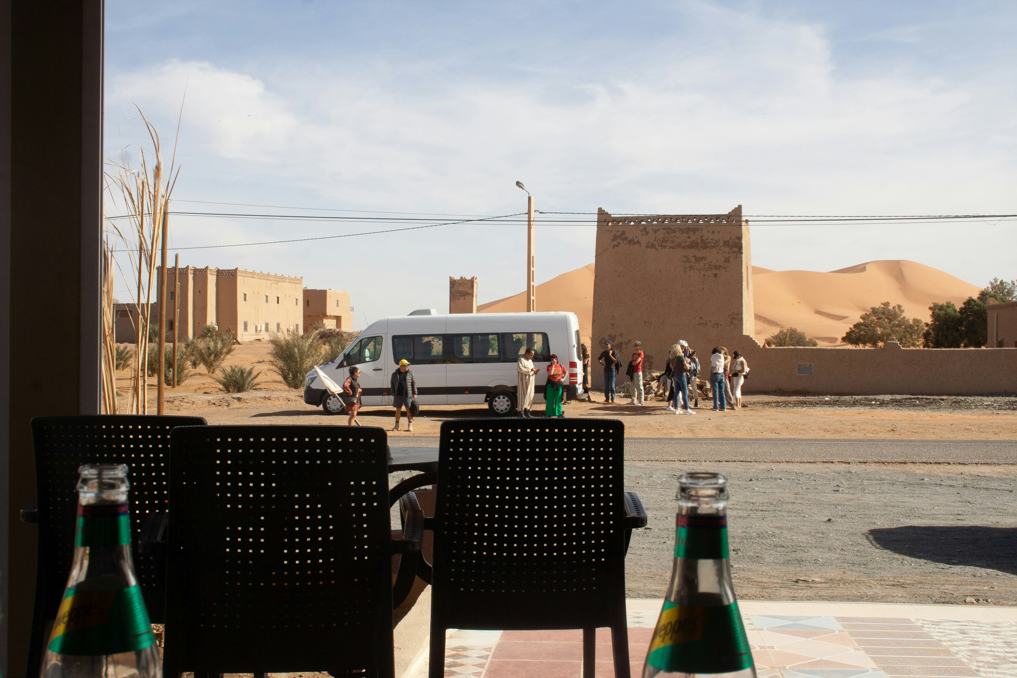 Desert Gate: Tour Bus Pauses by Sun-Baked Fortified Walls