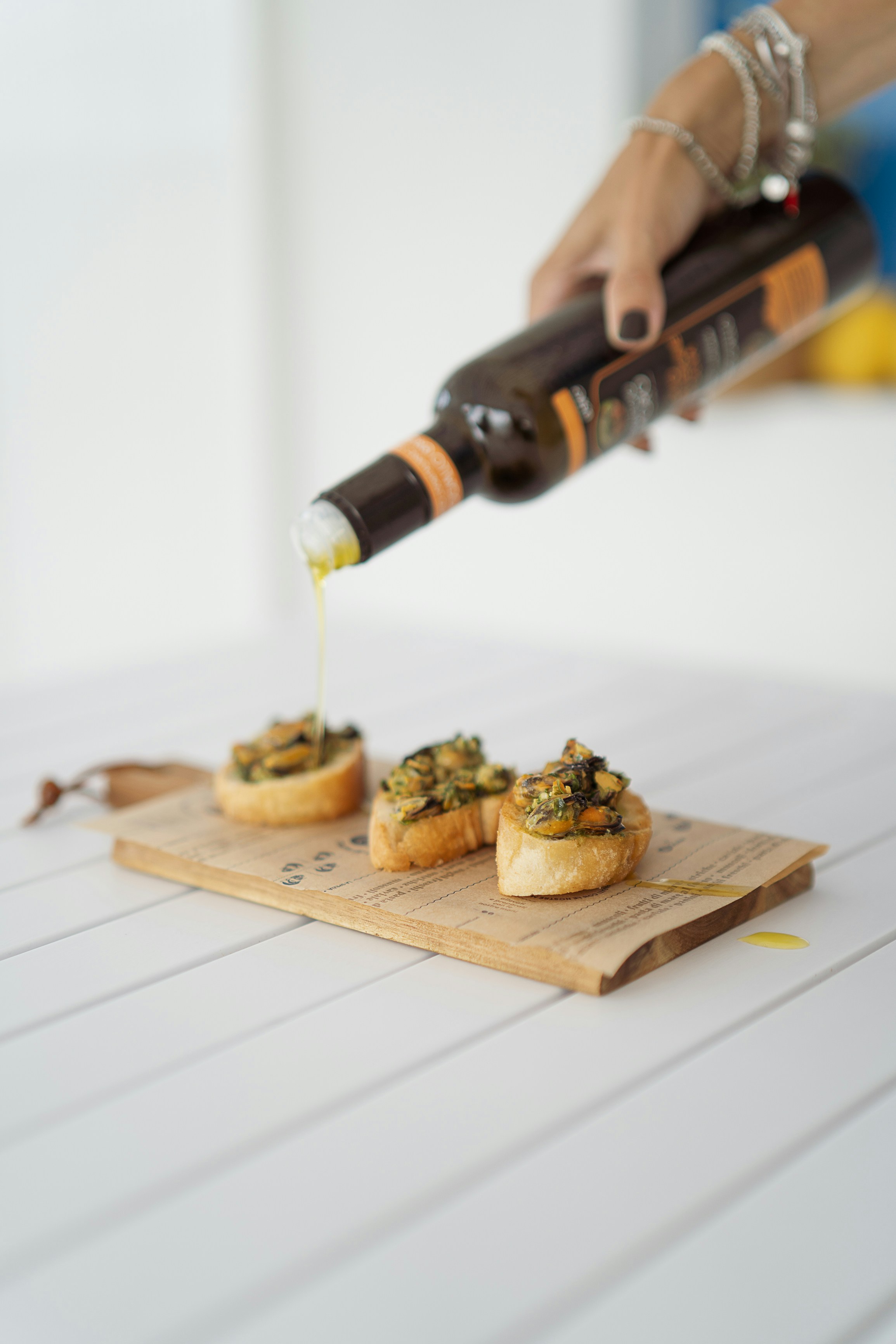 A person pouring olive oil on small appetizers photo – Free Food and ...