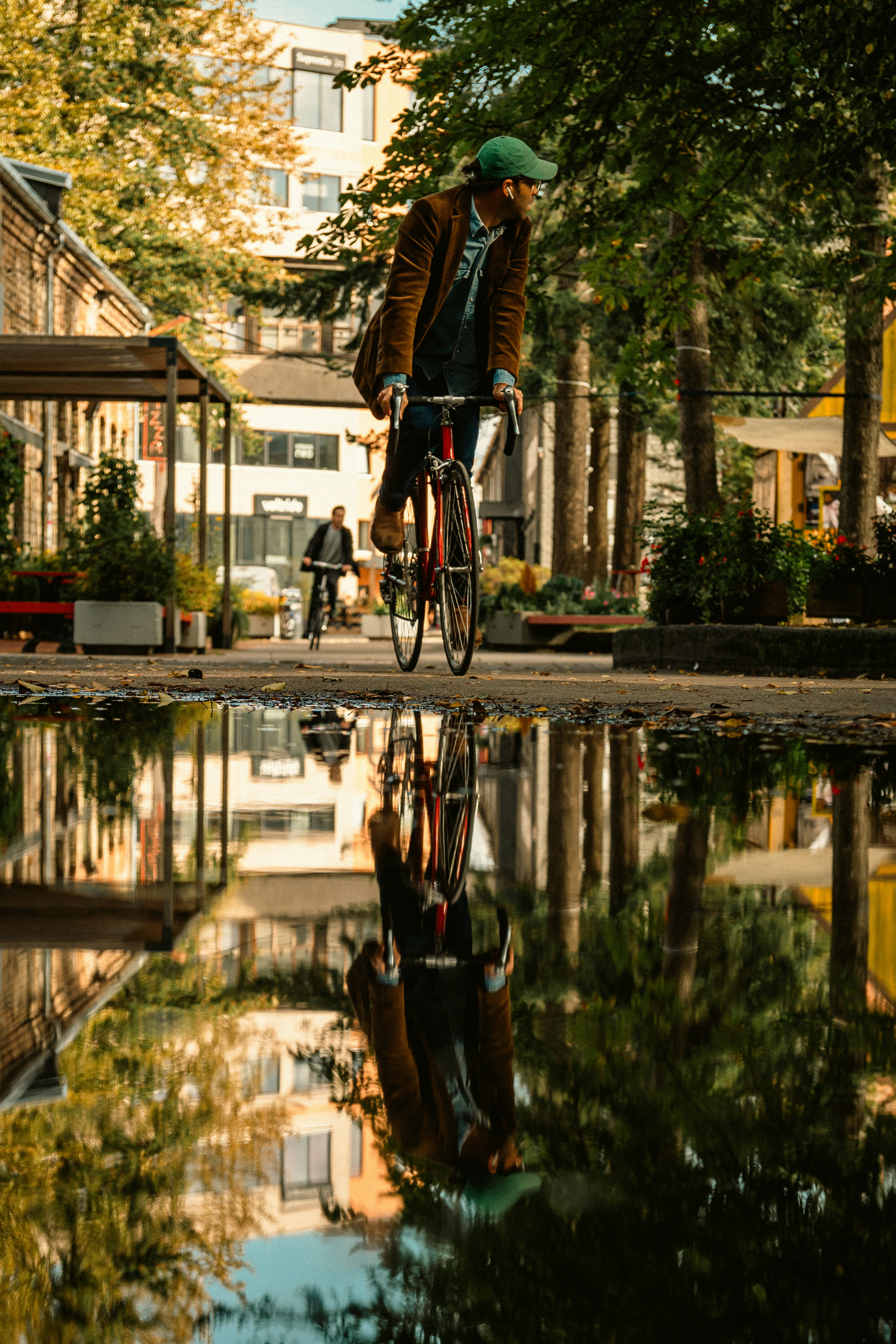A man riding a bike down a street next to a forestJan Ledermann