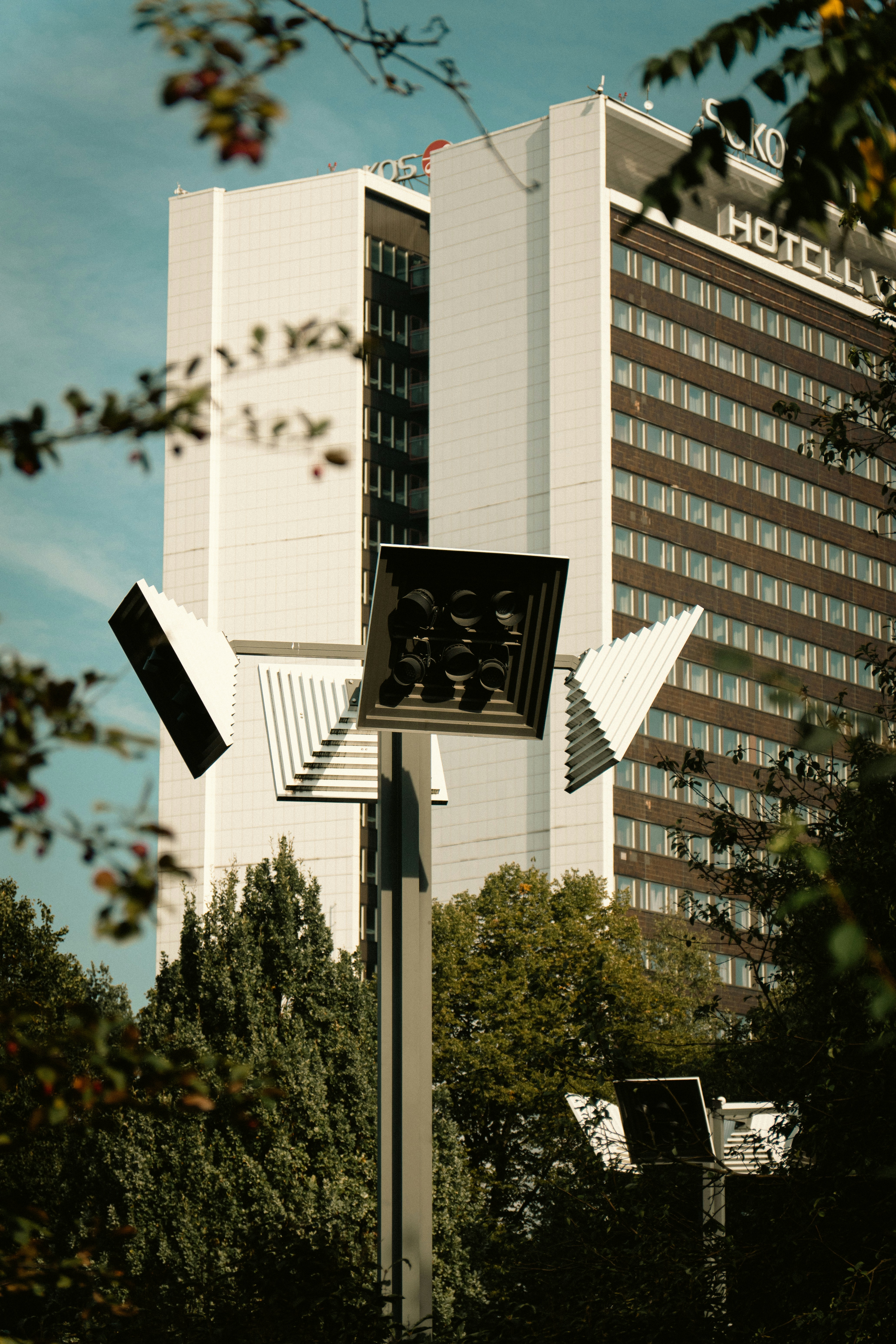 A clock on a pole in front of a tall building