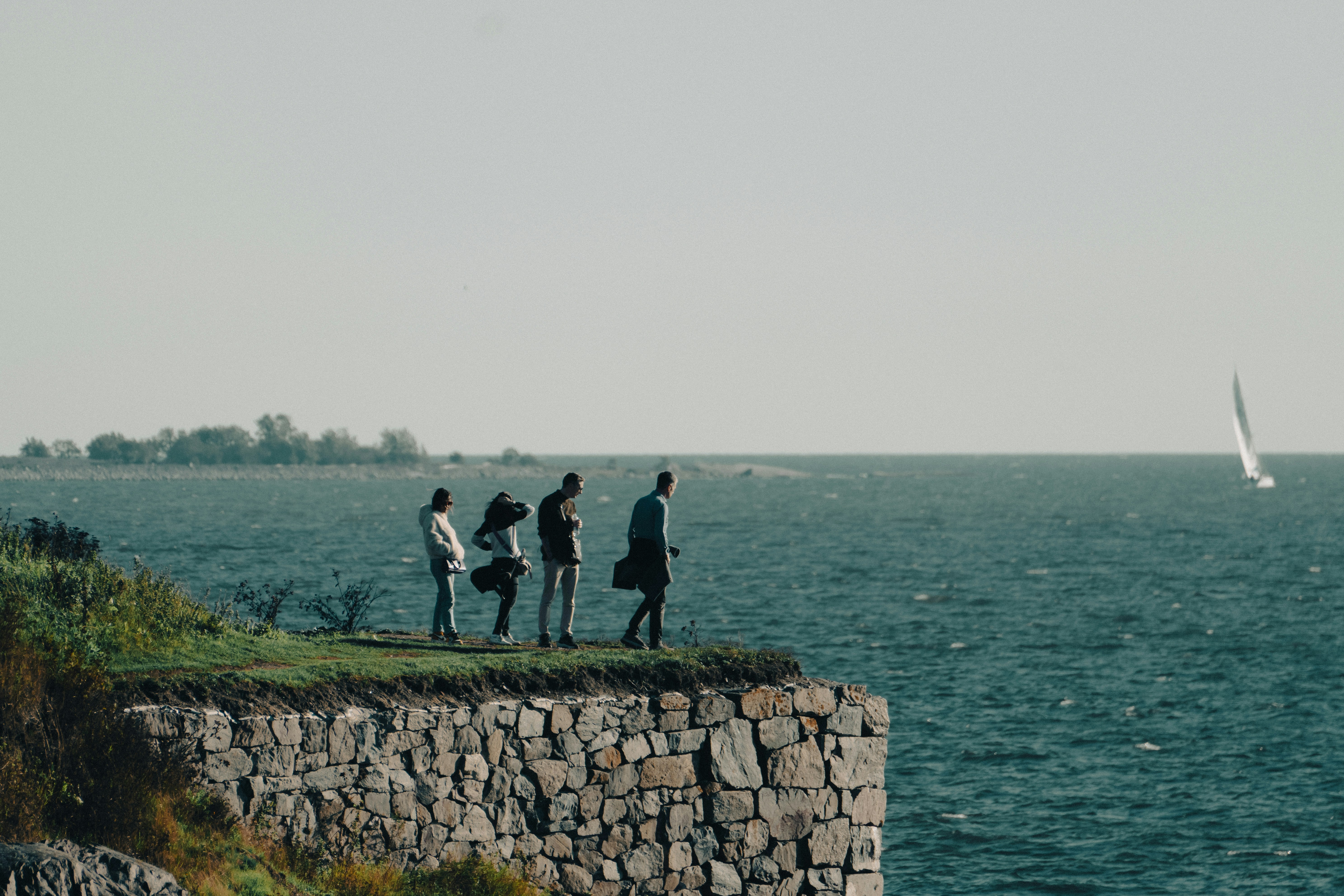 Promontory Portraits: Four silhouettes on a weathered cliff overlooking the sea