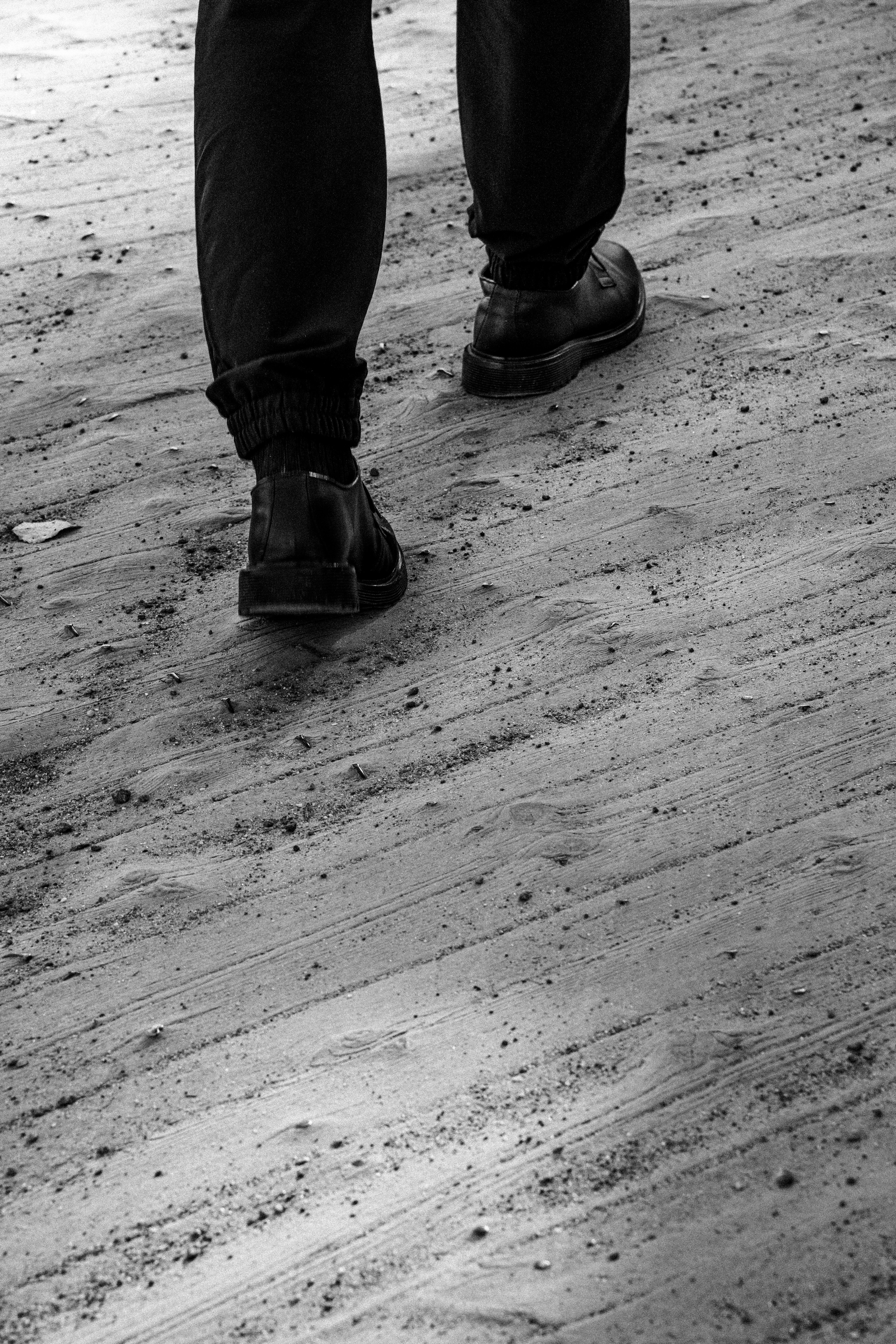 Whilst walking on the island Suomenlinna, Helsinki, Finland, I came upon a bridge made out of wood. This wood has been worn down by all the people walking on it, making the wood textured/bumpy. I loved this aspect which has been carved into the wood by thousands if not millions of people. Just in the right moment a man in an all black outfit crossed the bridge to the left of me. I took the opportunity and photographed him walking on the wood bridge.Jan Ledermann