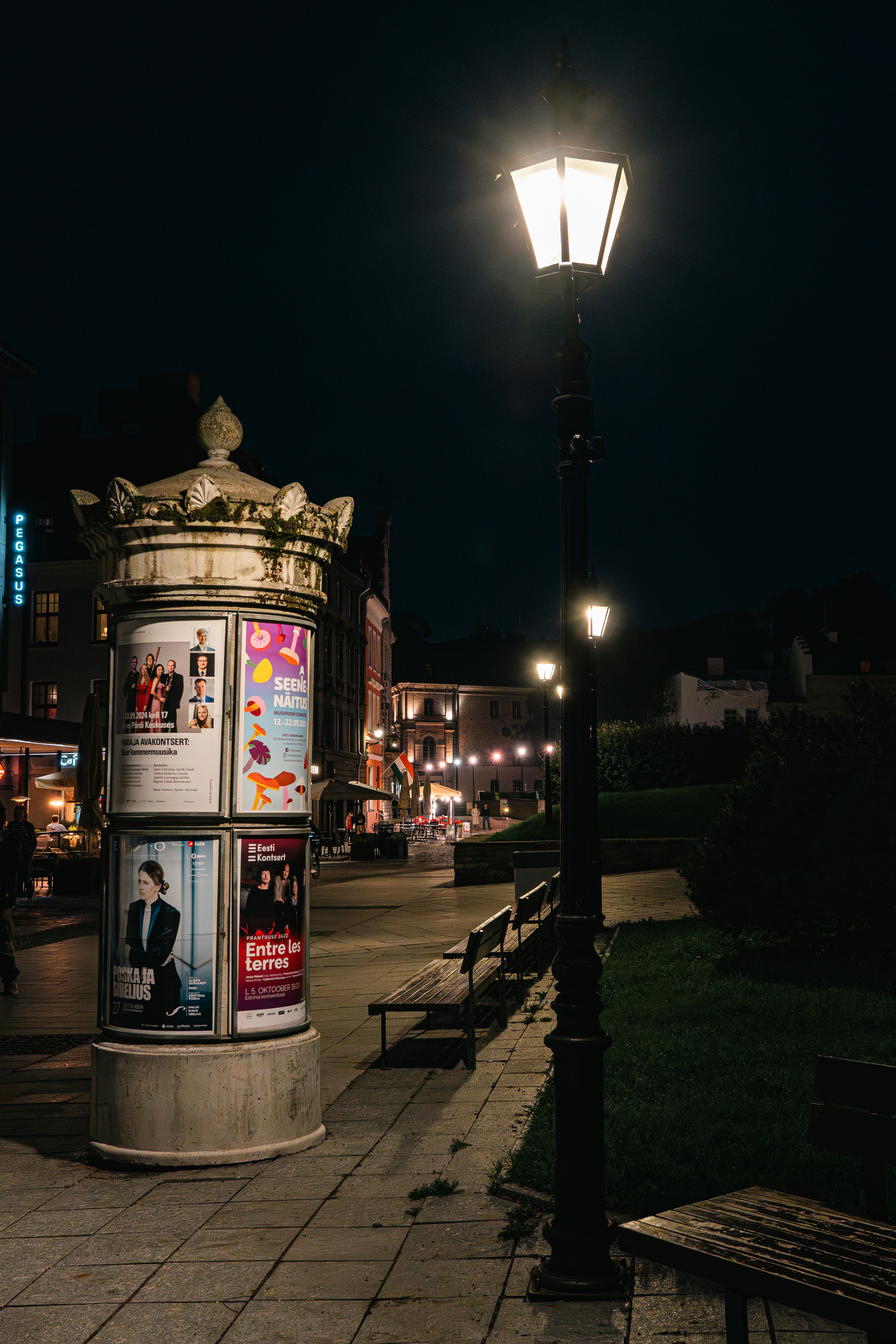 Gaslight and Poster Columns: Night Glow on a Quiet City Street