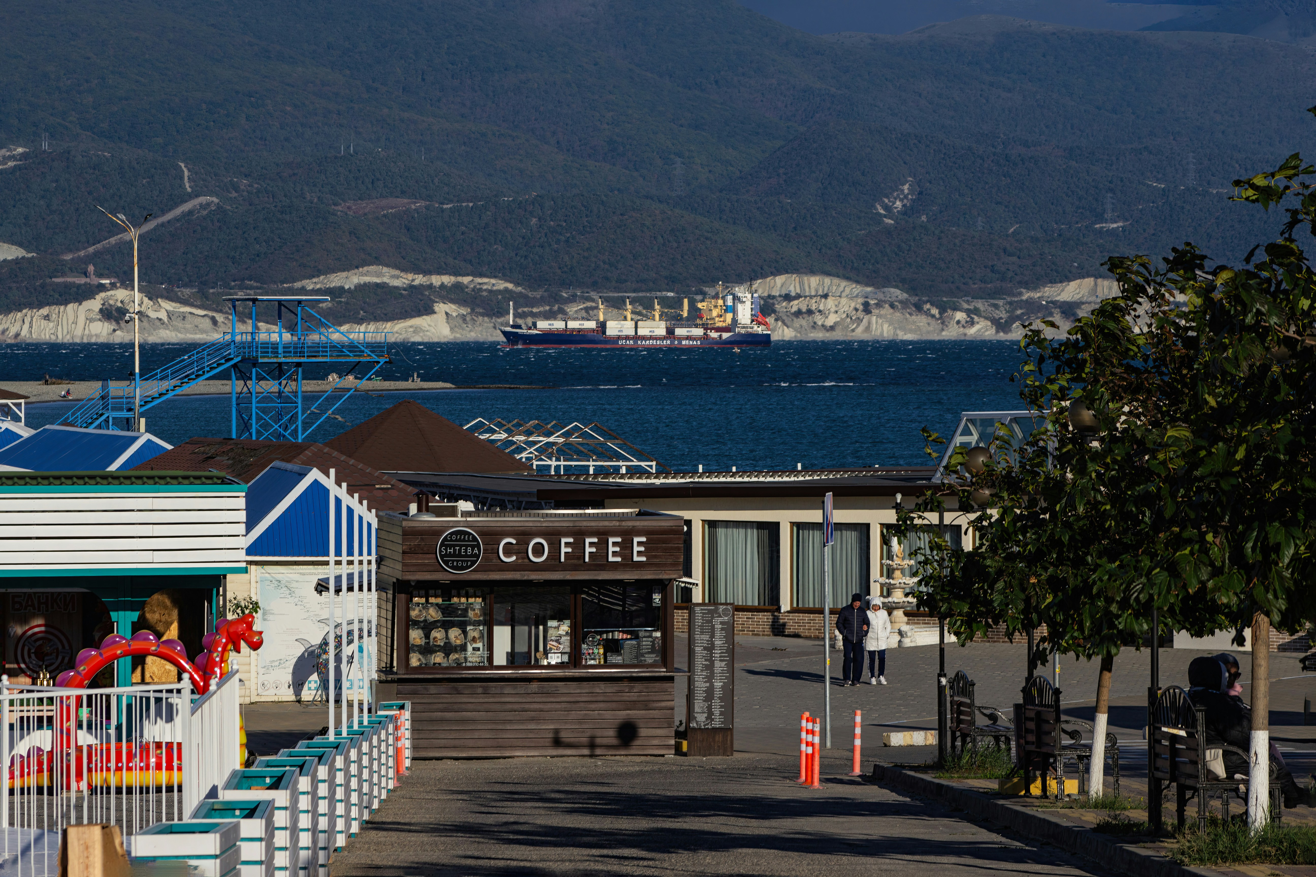 Harbor Promenade Café Under a Freighter’s Horizon