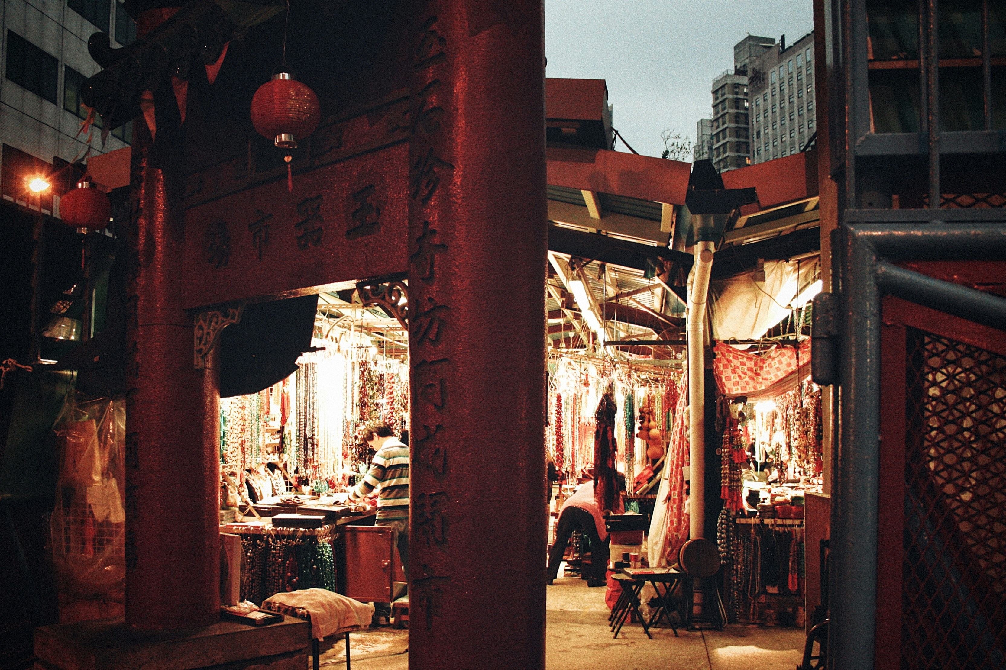 Lantern-lit Market Corners: A Red Archway Framing a Glow of Stalls