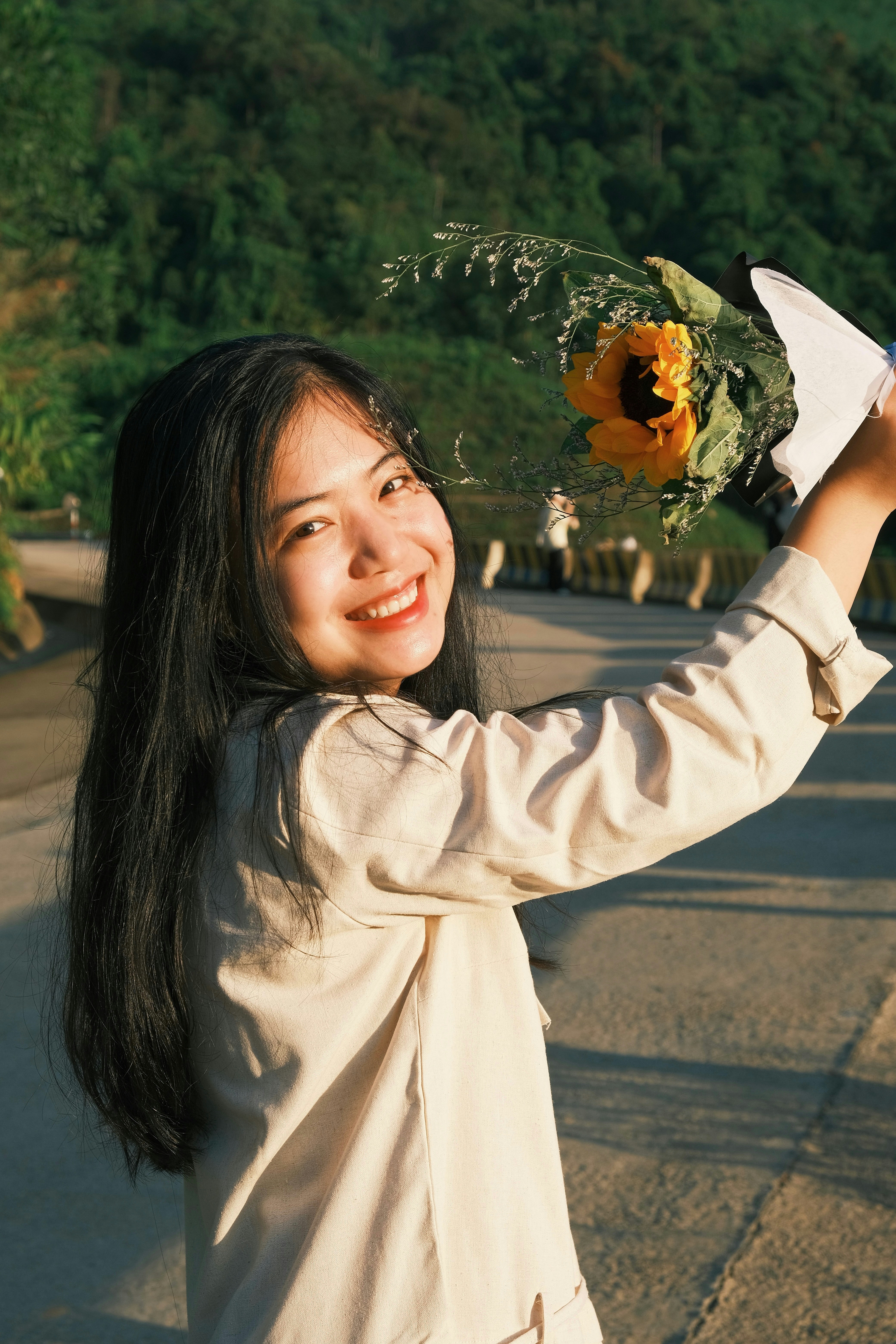 Golden Hour Portrait: A Sunflower Bouquet and a Radiant Smile on a Quiet Road