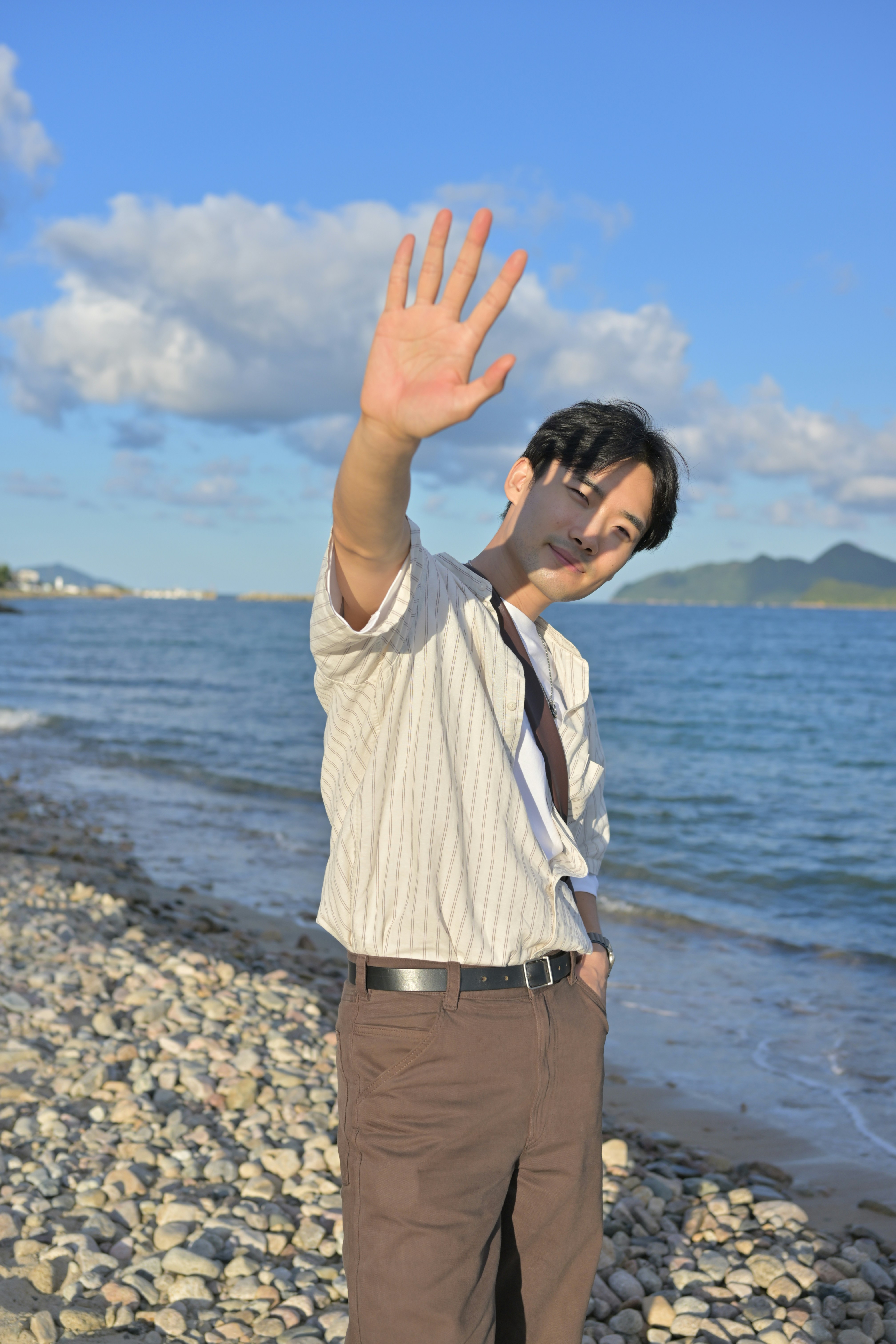 A man standing on top of a beach next to the ocean