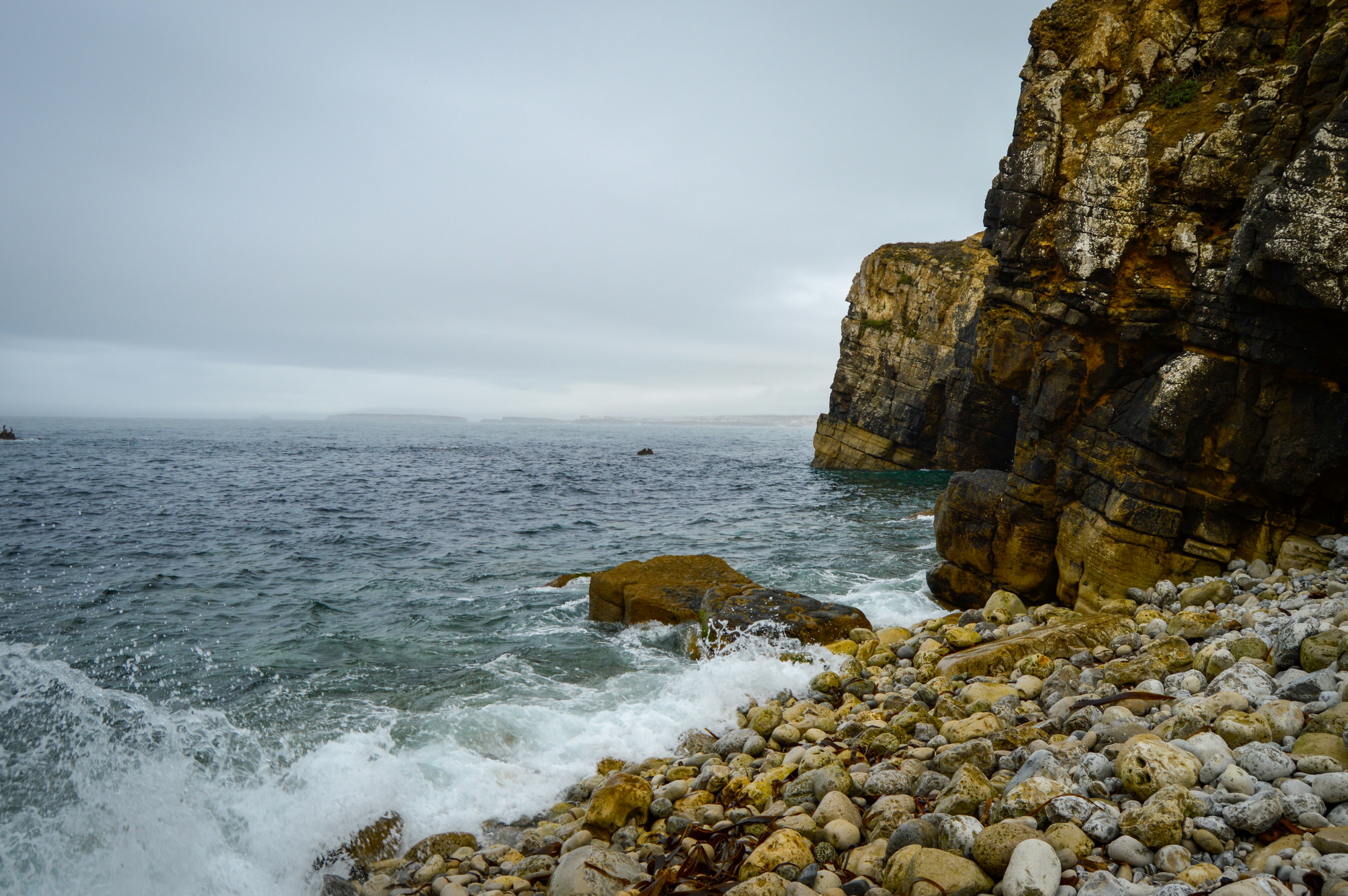 A rocky shore with waves crashing against the rocks photo – Free Rock ...