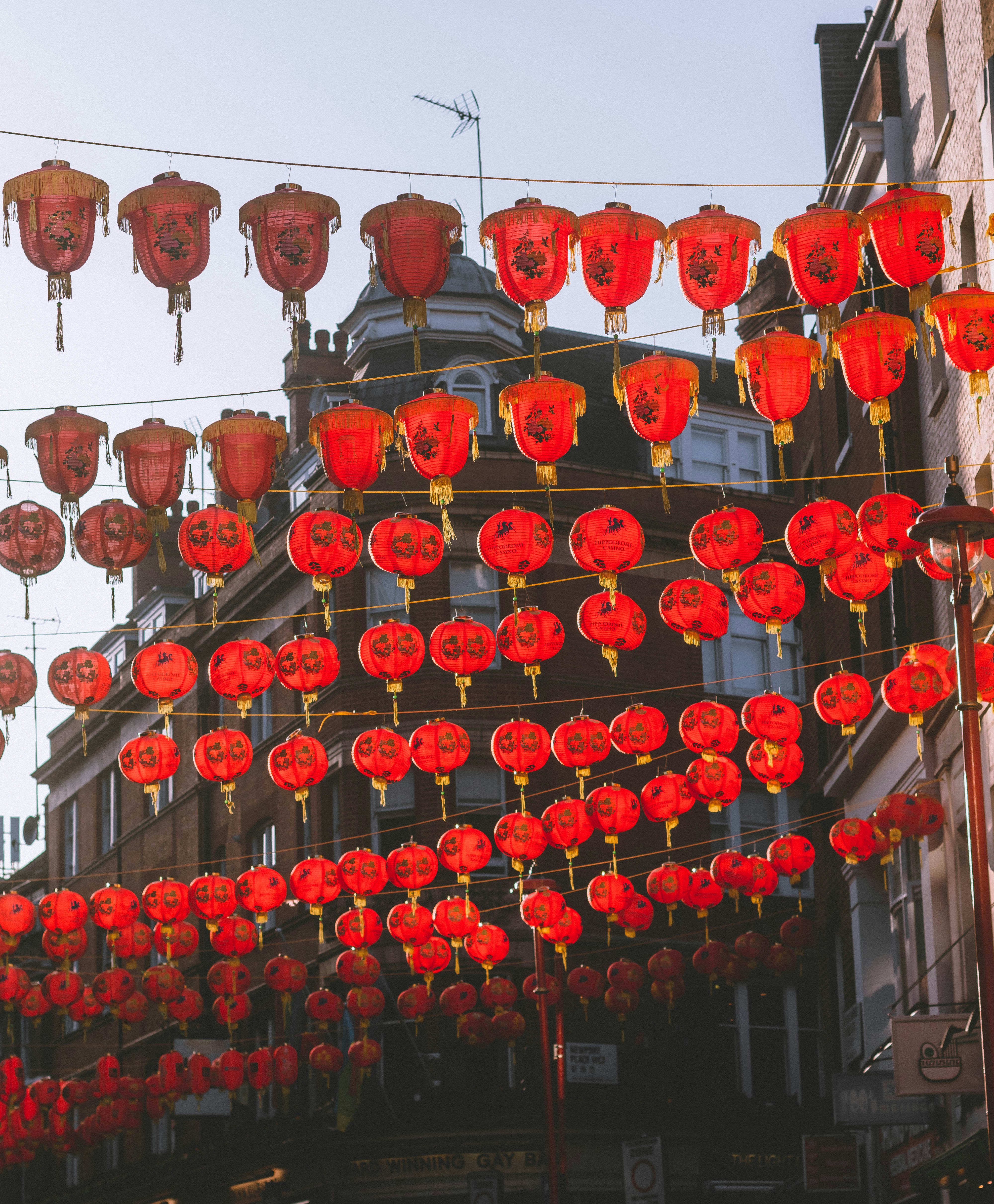 A mesmerizing display of red lanterns strung across a street, celebrating cultural festivities. The warm light creates an inviting atmosphere.