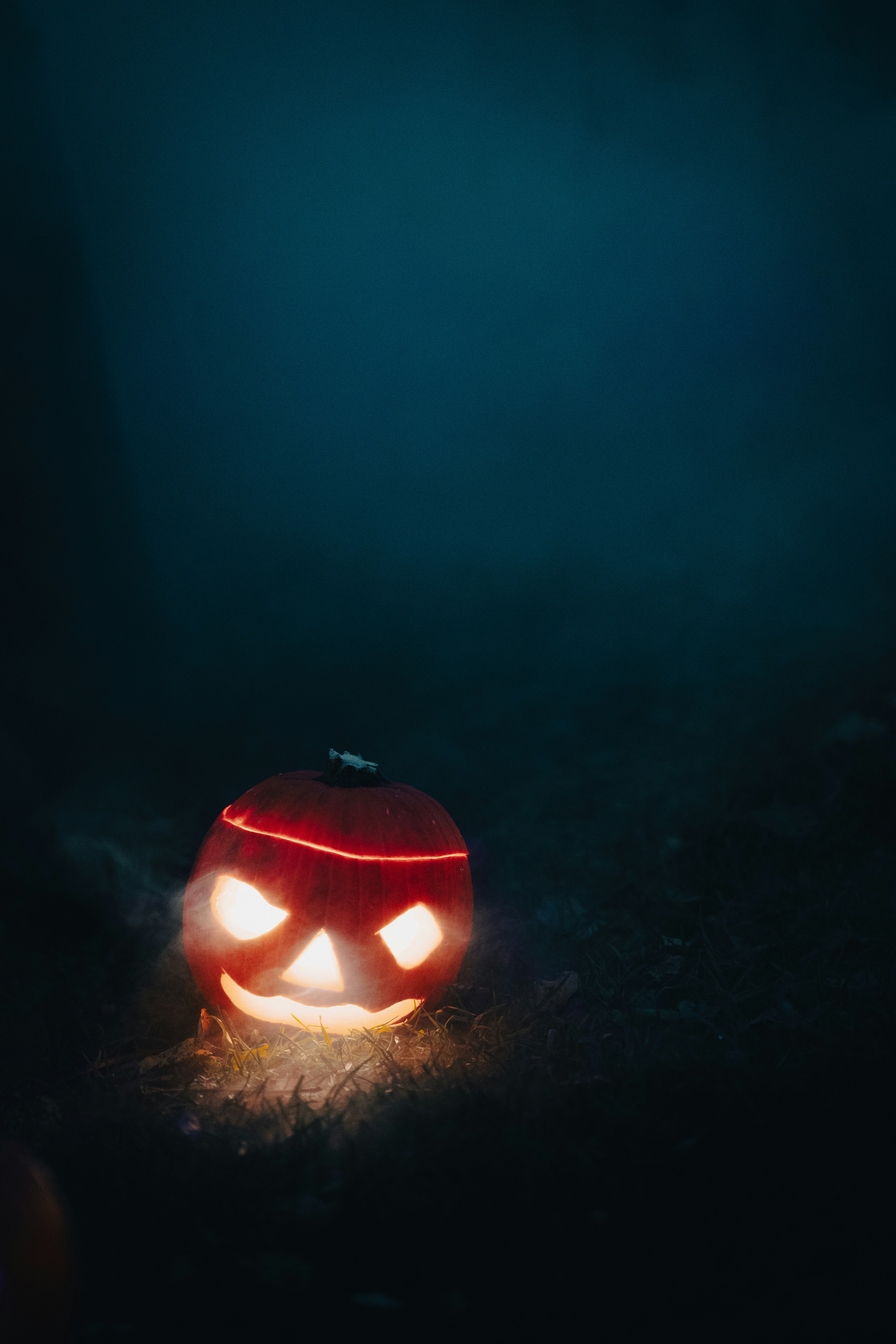 Midnight Ember: A Lone Pumpkin Casting Warm Light Through Fog