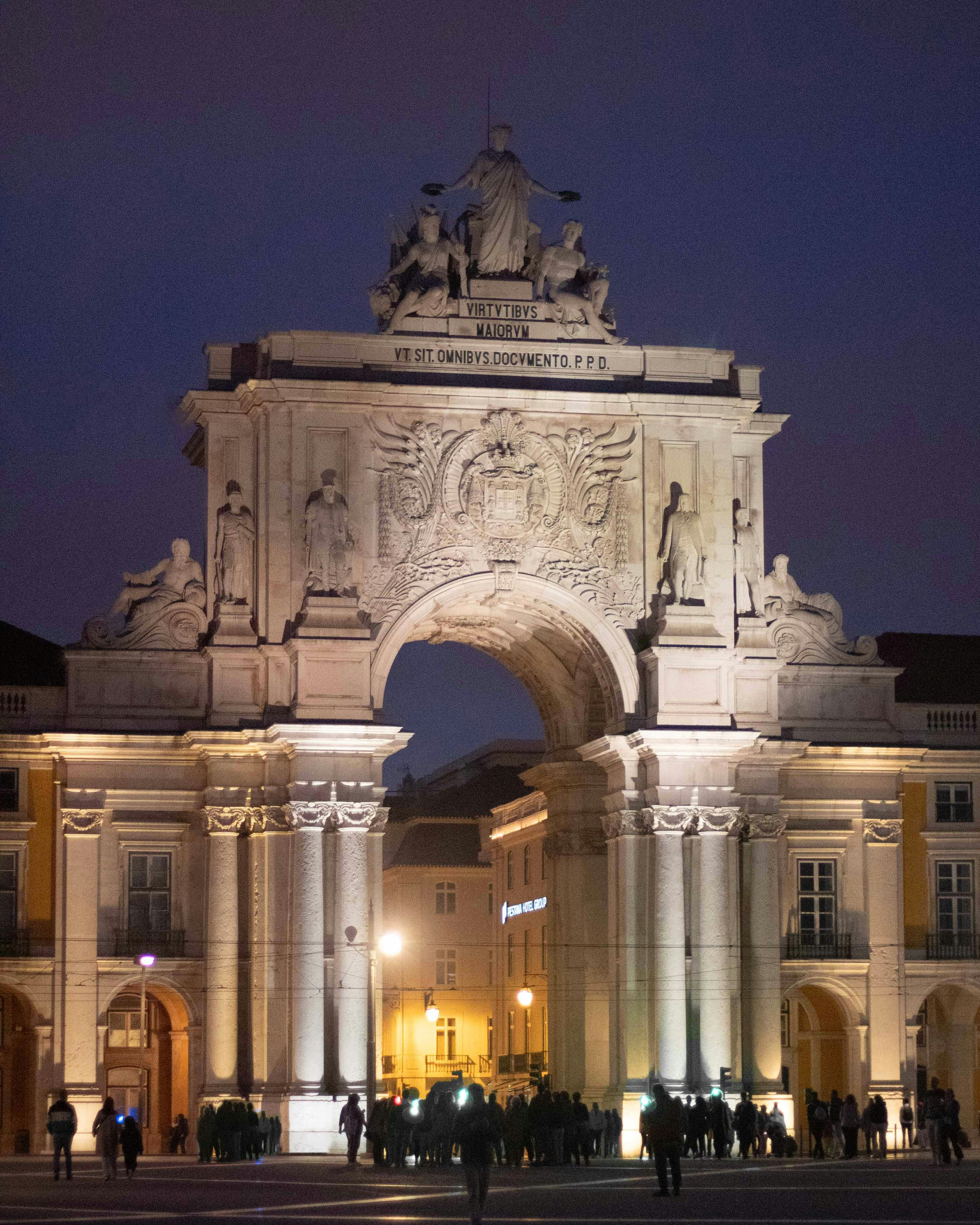 A very tall building with a massive arch at night photo – Free Building ...