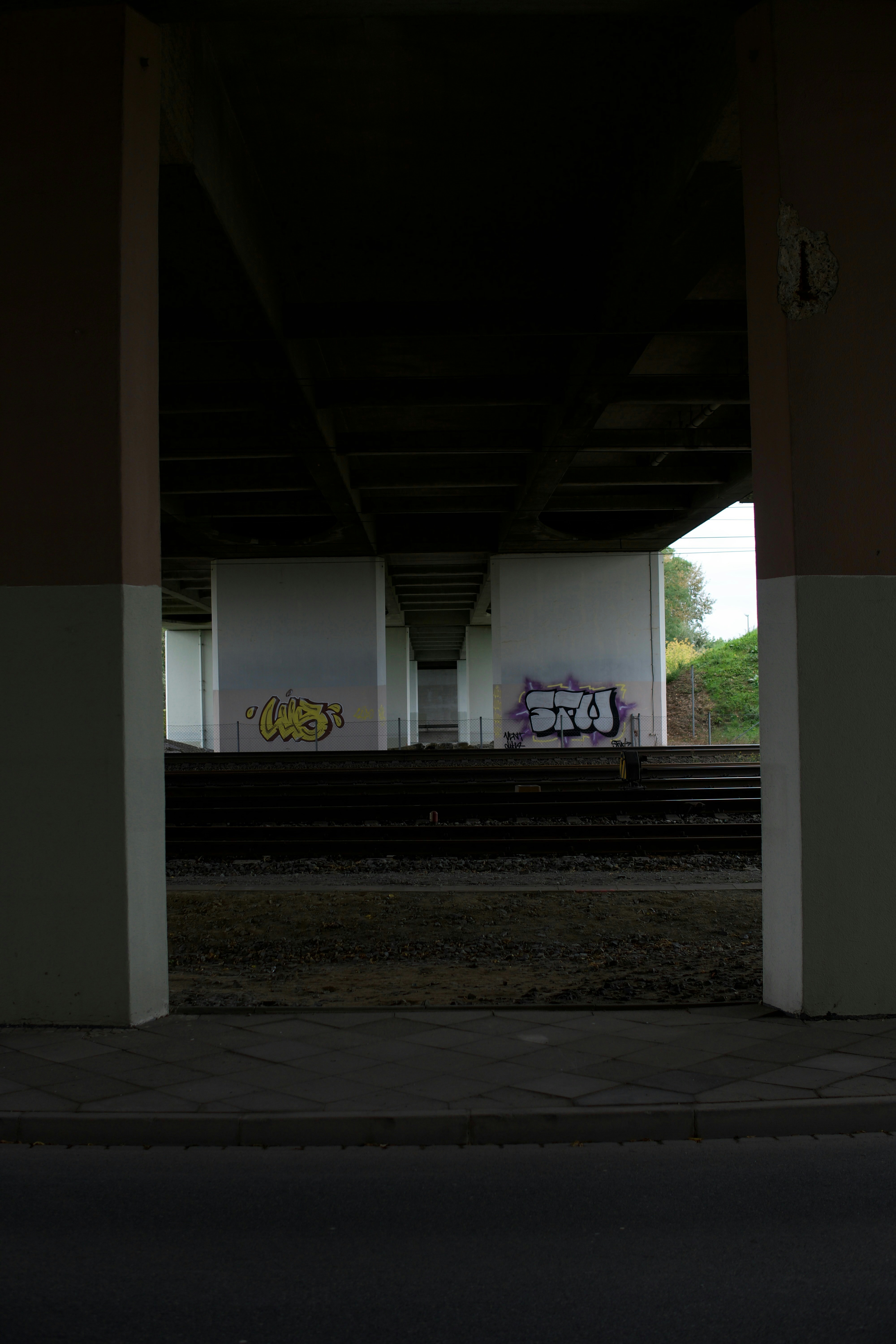 A train track under a bridge with graffiti on it photo – Free Building ...