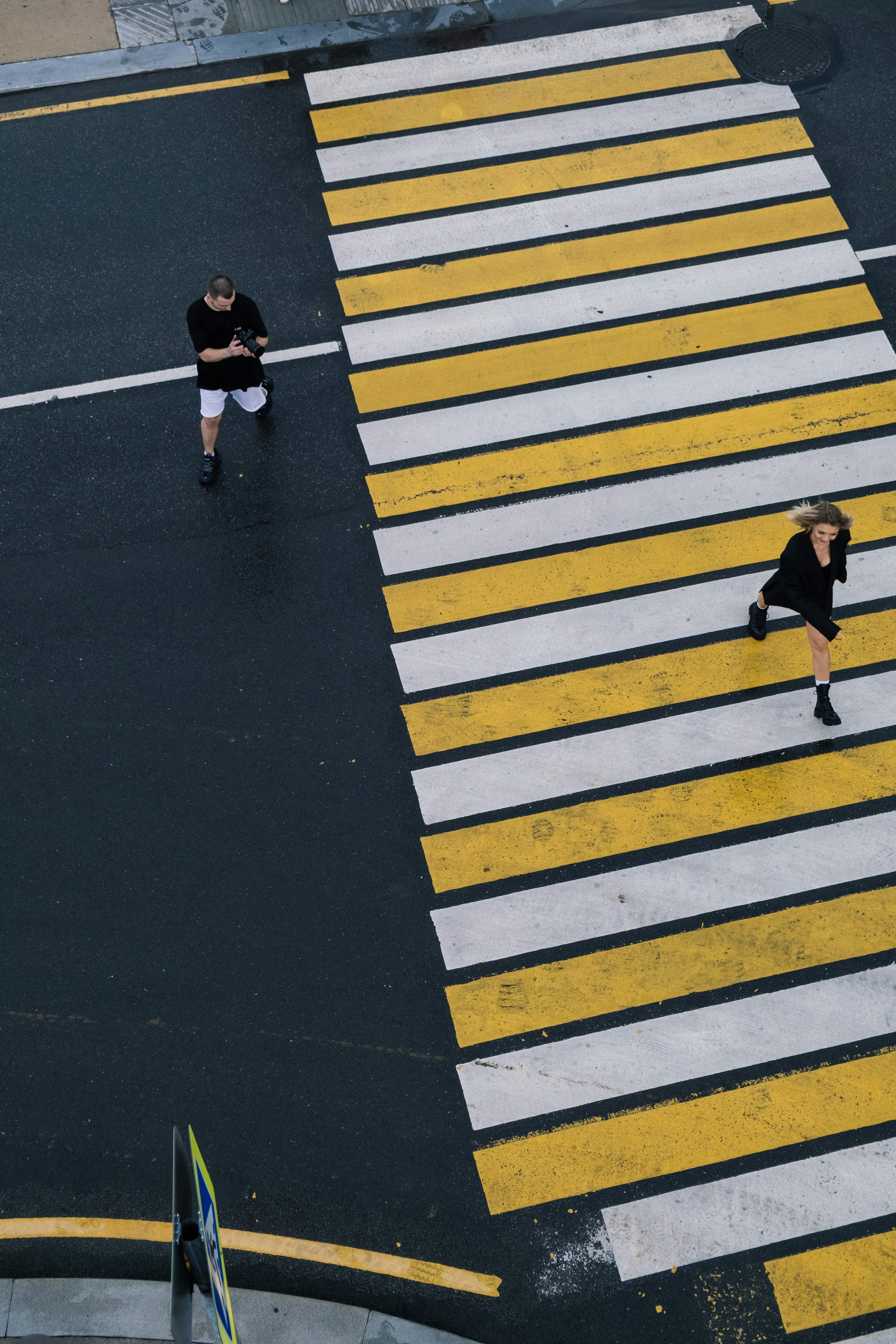 A couple of people walking across a cross walk