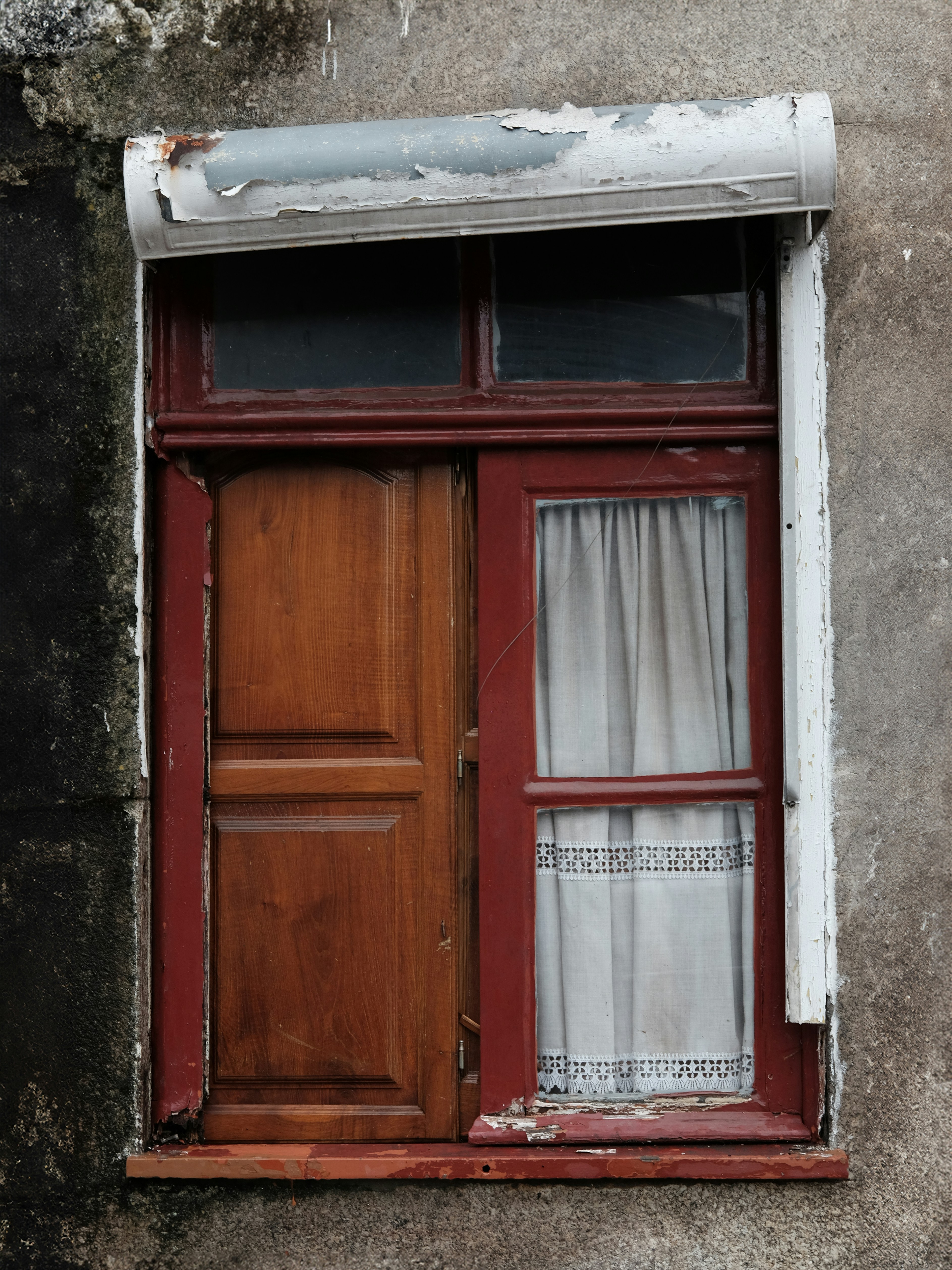 Red-Framed Window in Weathered Concrete: A Quiet Facade Portrait