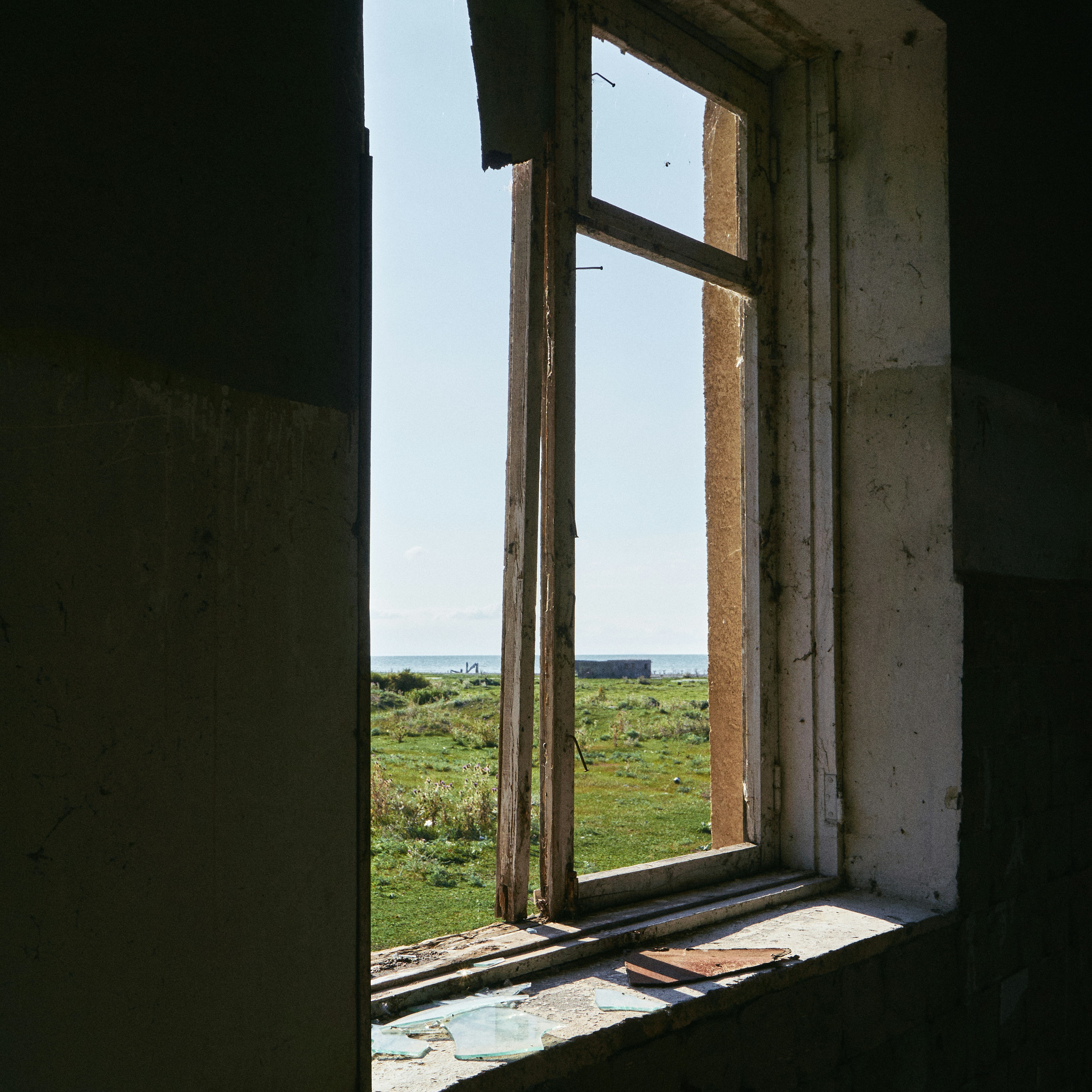 Through the Weathered Window: A Quiet Seaside View from a Crumbling Room