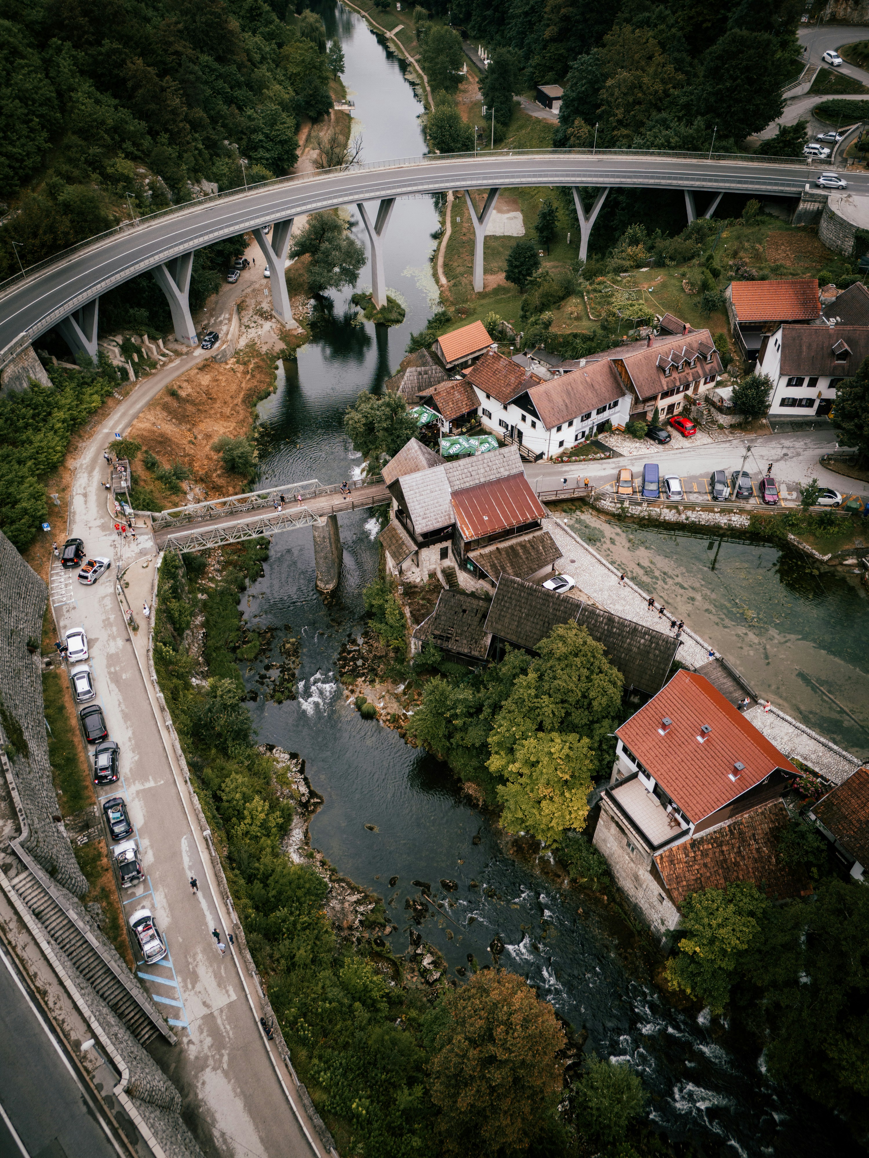 Curved Viaduct Over a Riverscape: A Nestled Village with Red Roofs