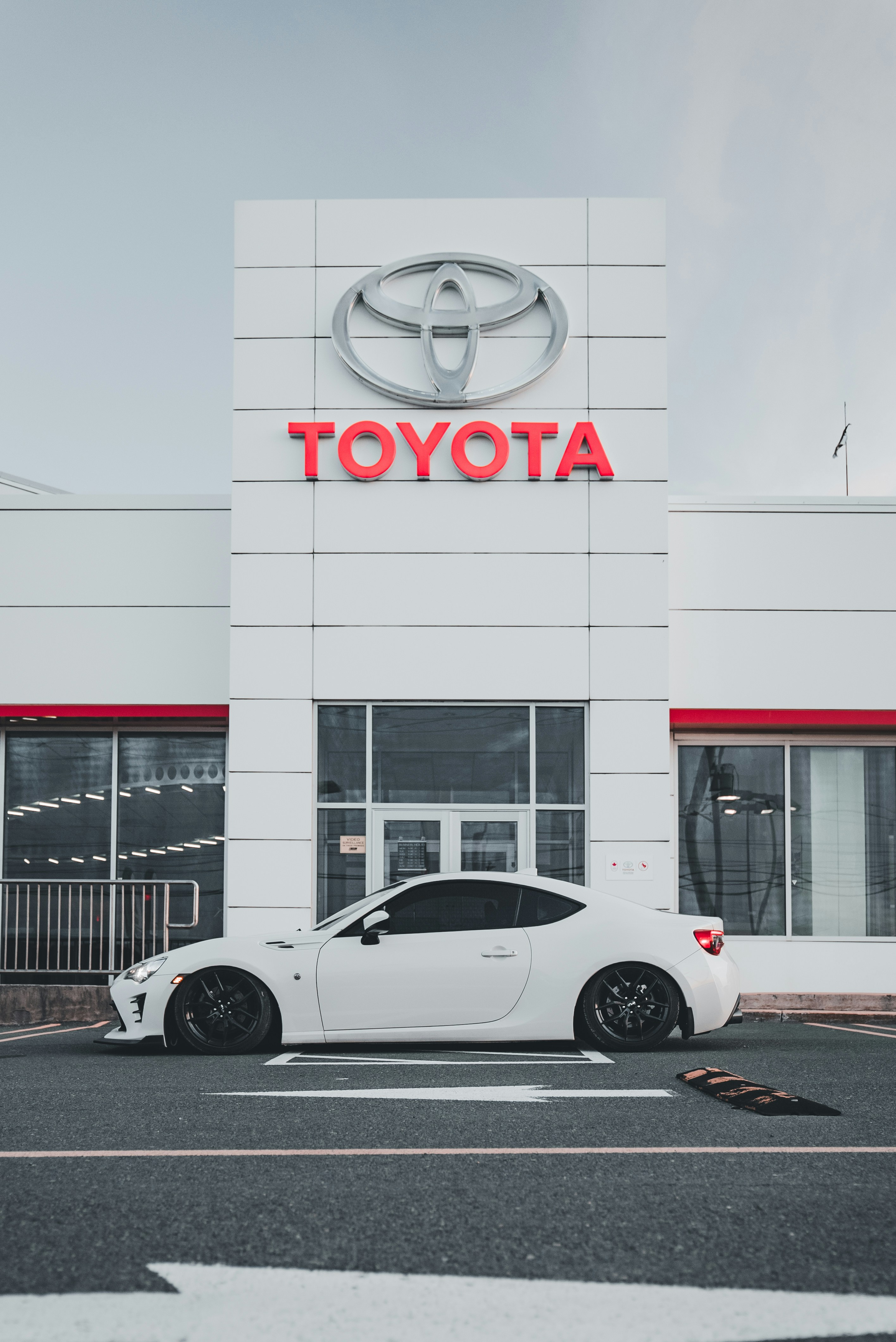 A toyota dealership with a white car parked in front of it photo – Free ...