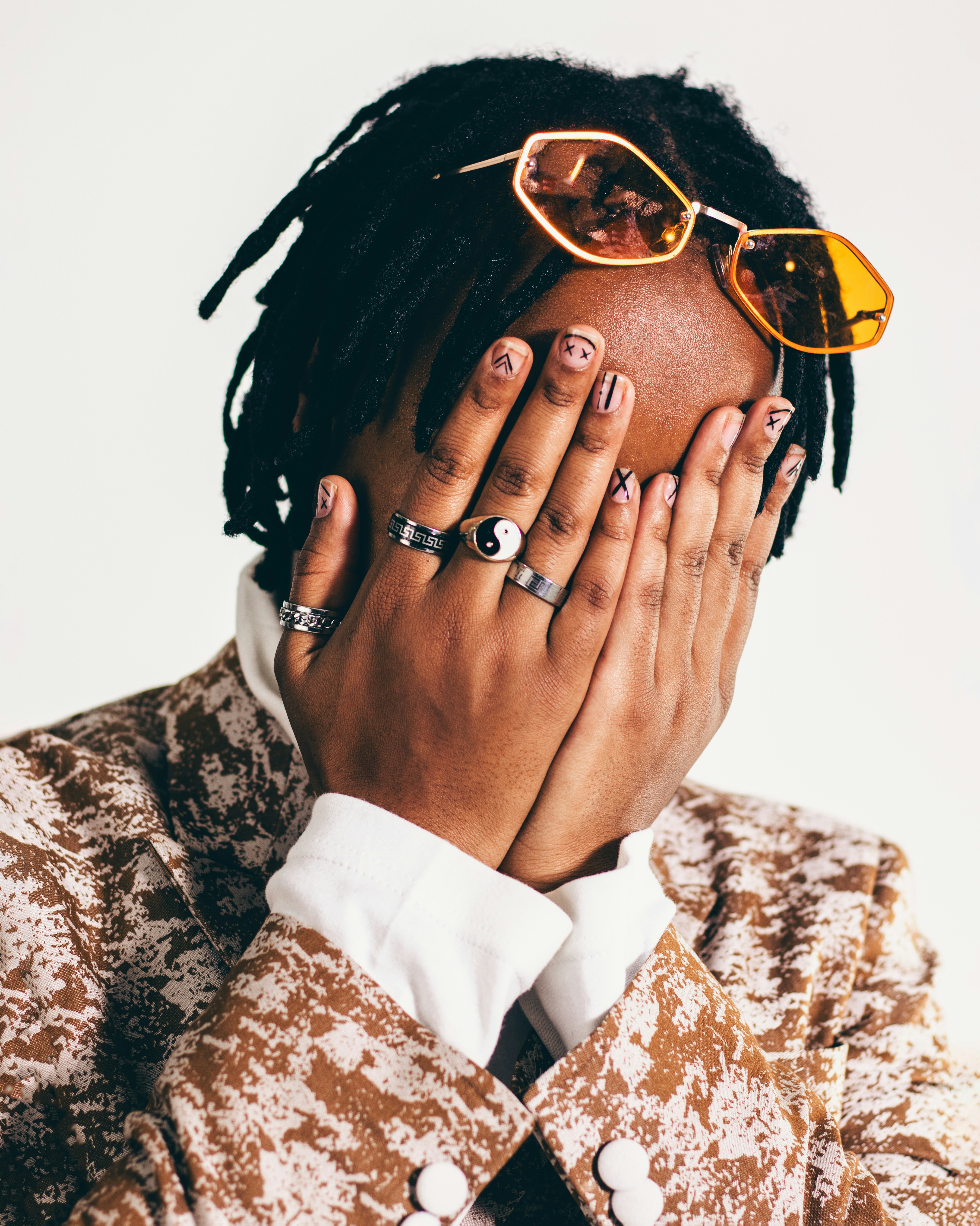 A man with dreadlocks covering his face with his hands photo – Free ...