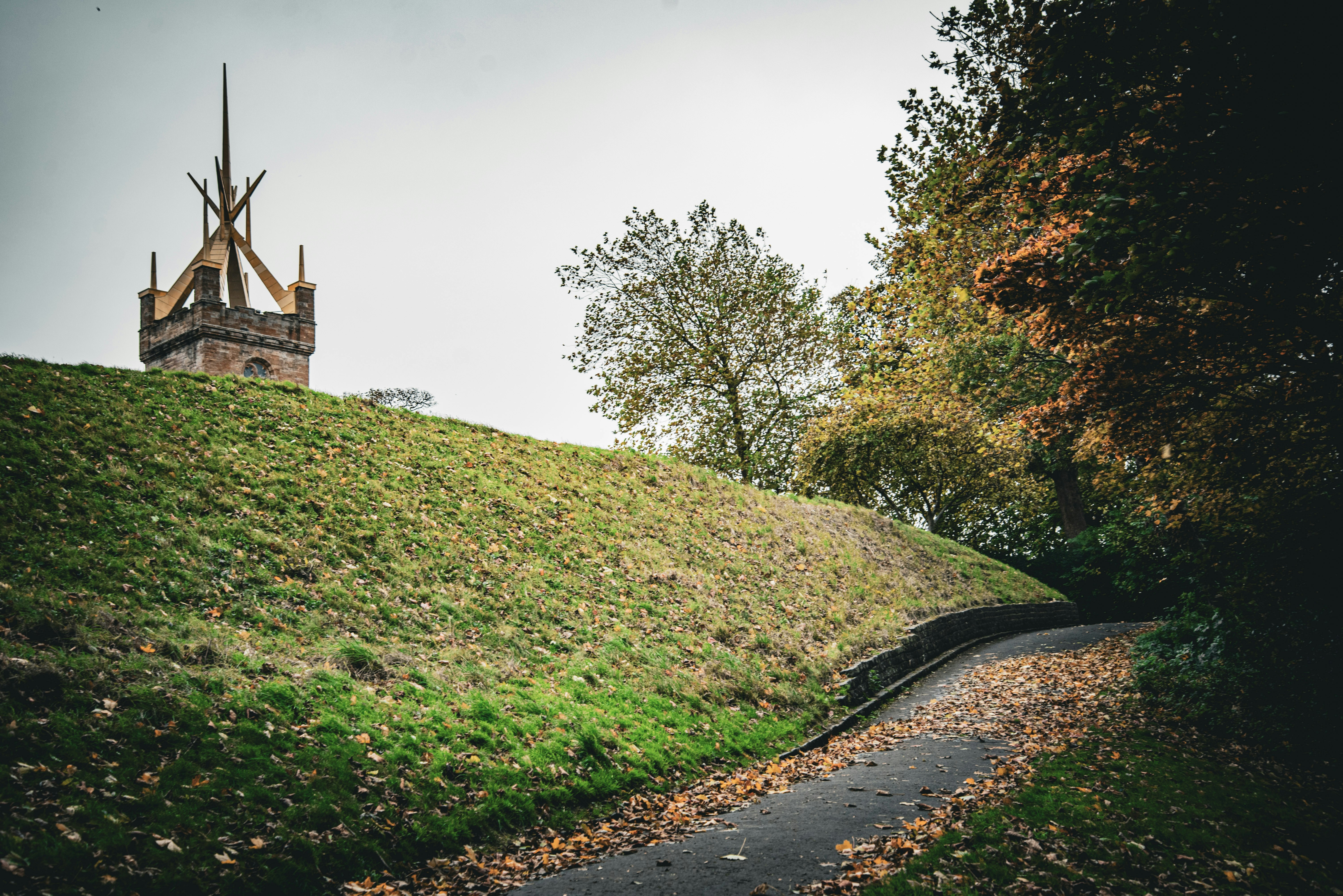 Hilltop Ruin with Timber Spires Over a Leaf-Strewn Path