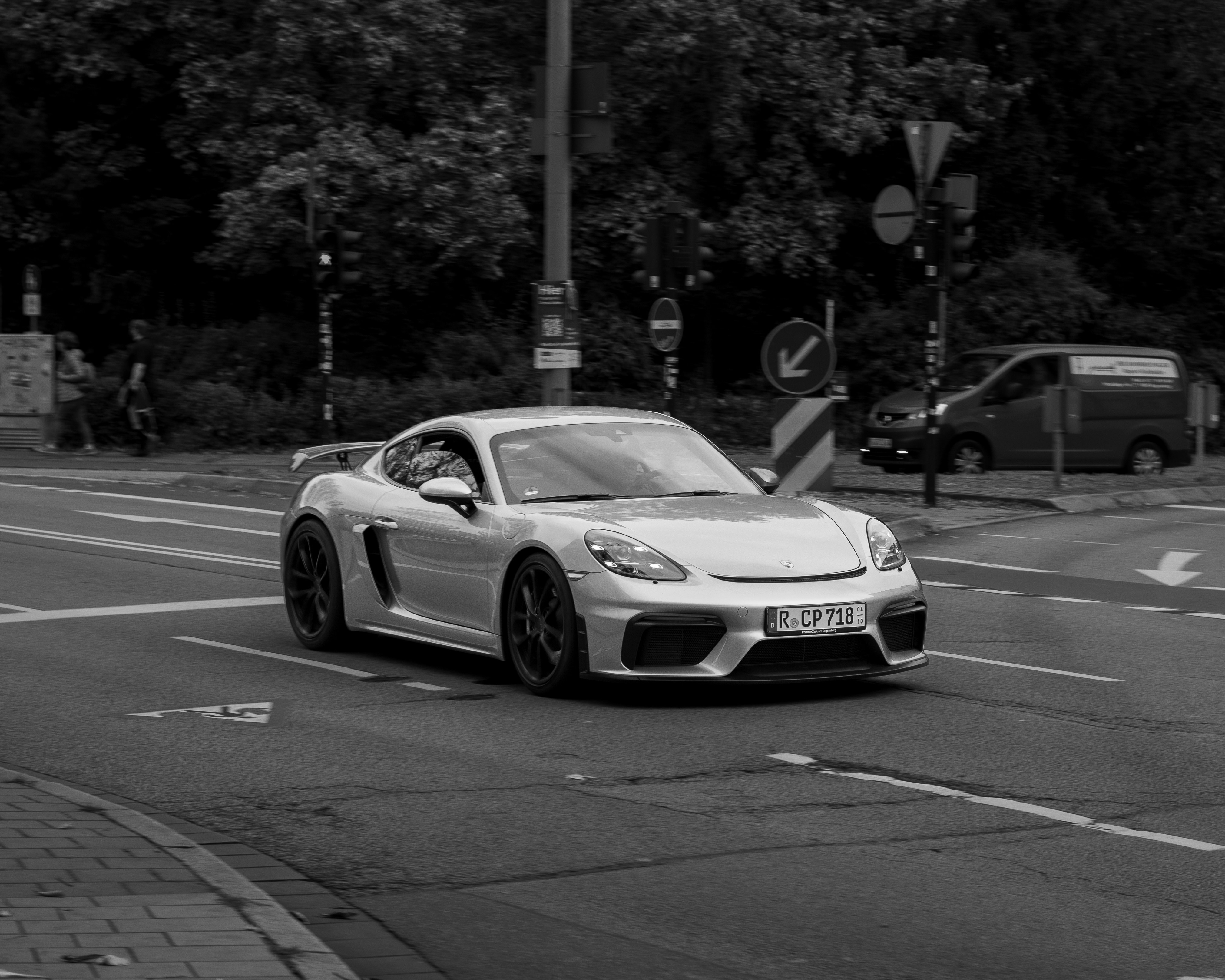 White Porsche Cayman Navigates a Quiet City Intersection in Monochrome