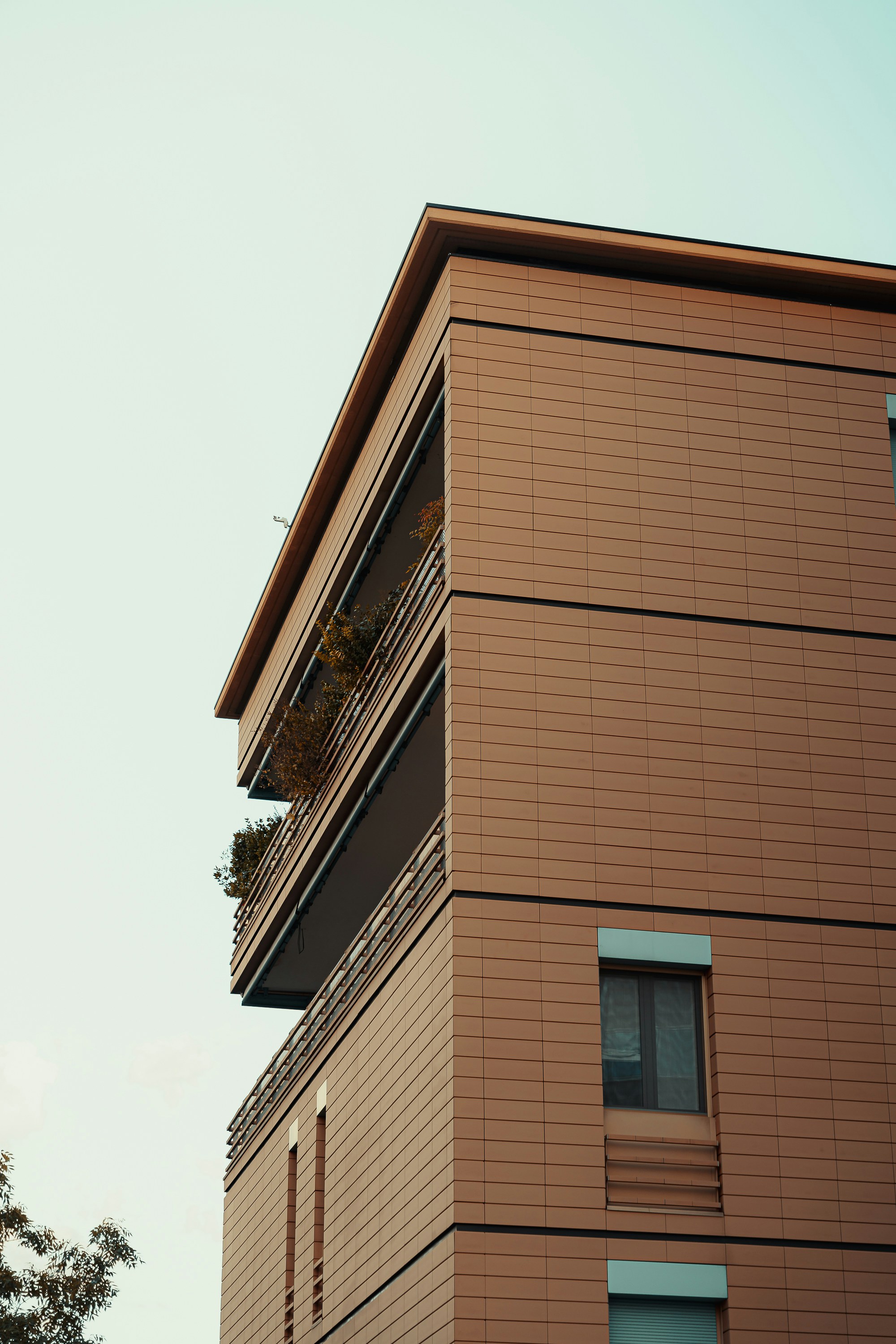 Modern geometric building with clean lines and warm tones against a clear sky.