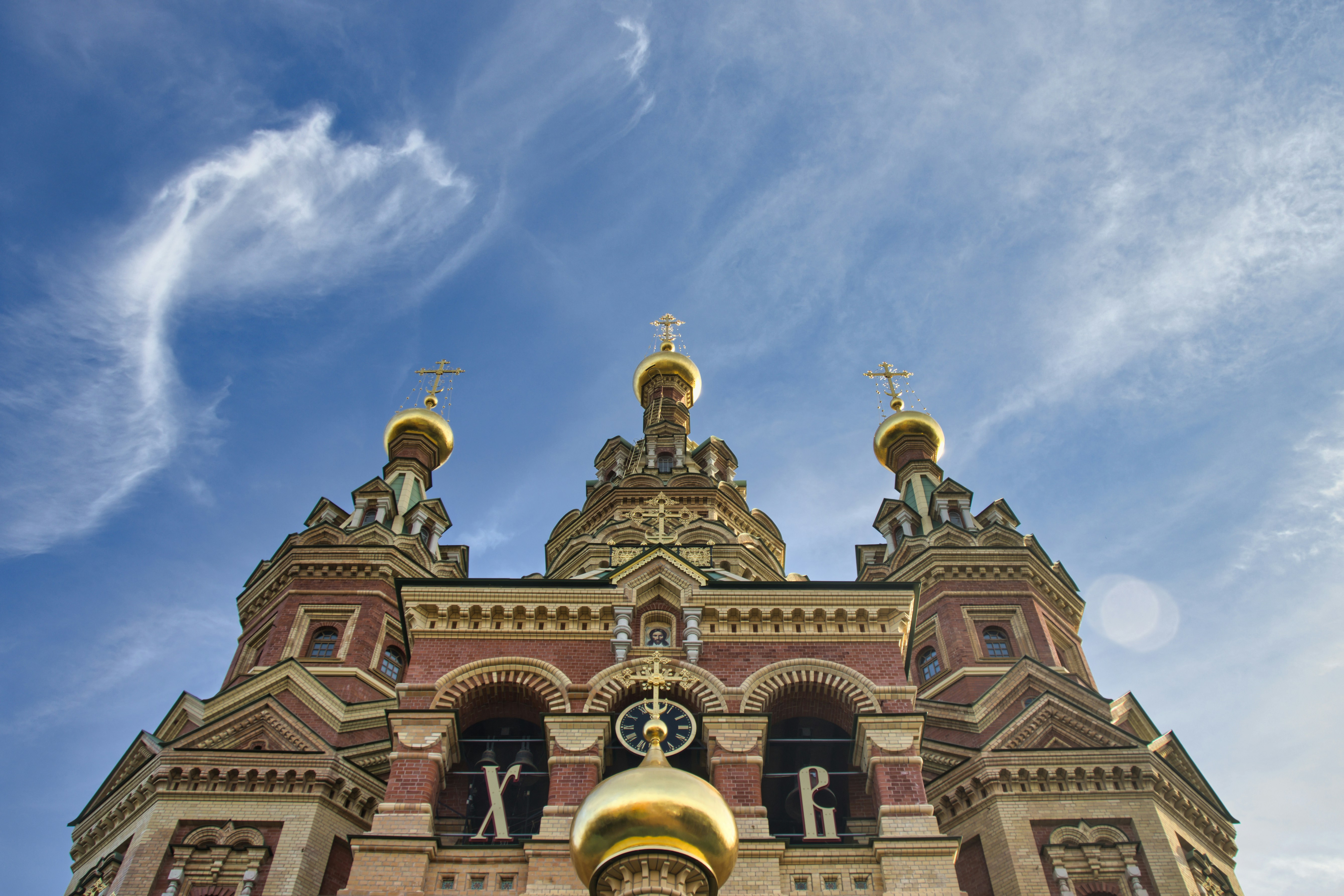 Gold Domes Crown a Brick Cathedral Against a Clear Blue Sky