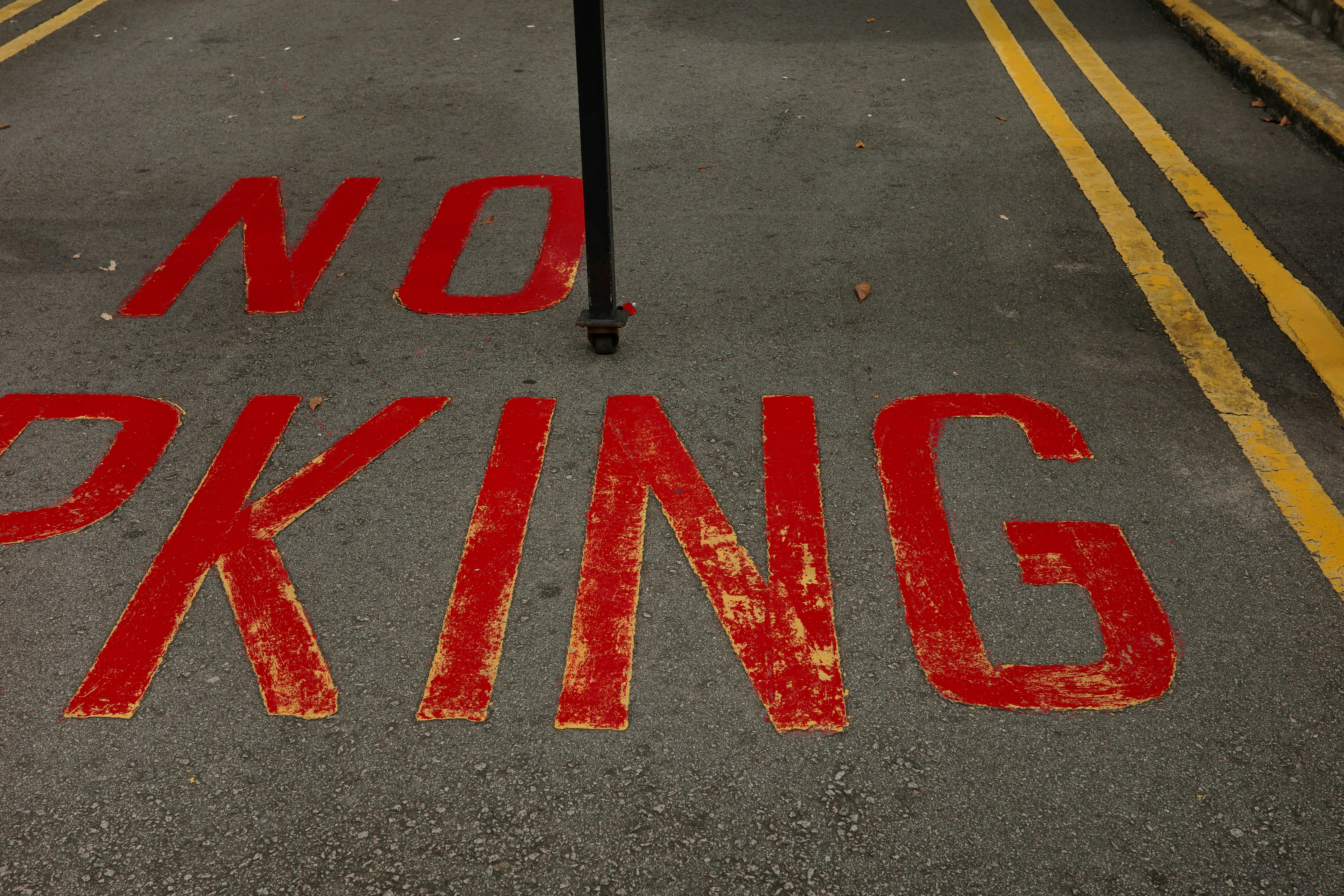 Scarlet Stencil on Asphalt: No Parking Message at Street Level