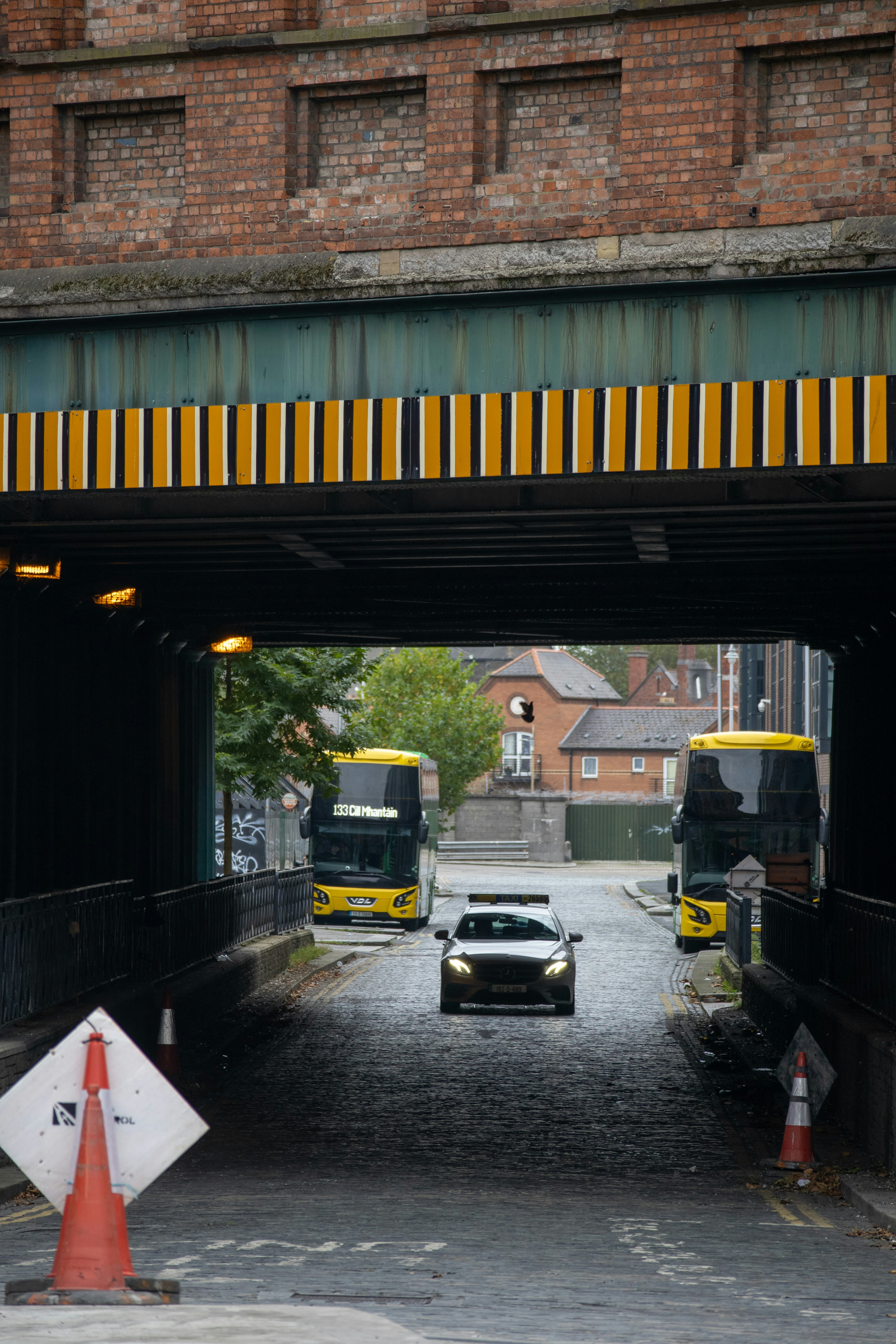 A couple of buses that are going under a bridge photo – Free Car Image ...