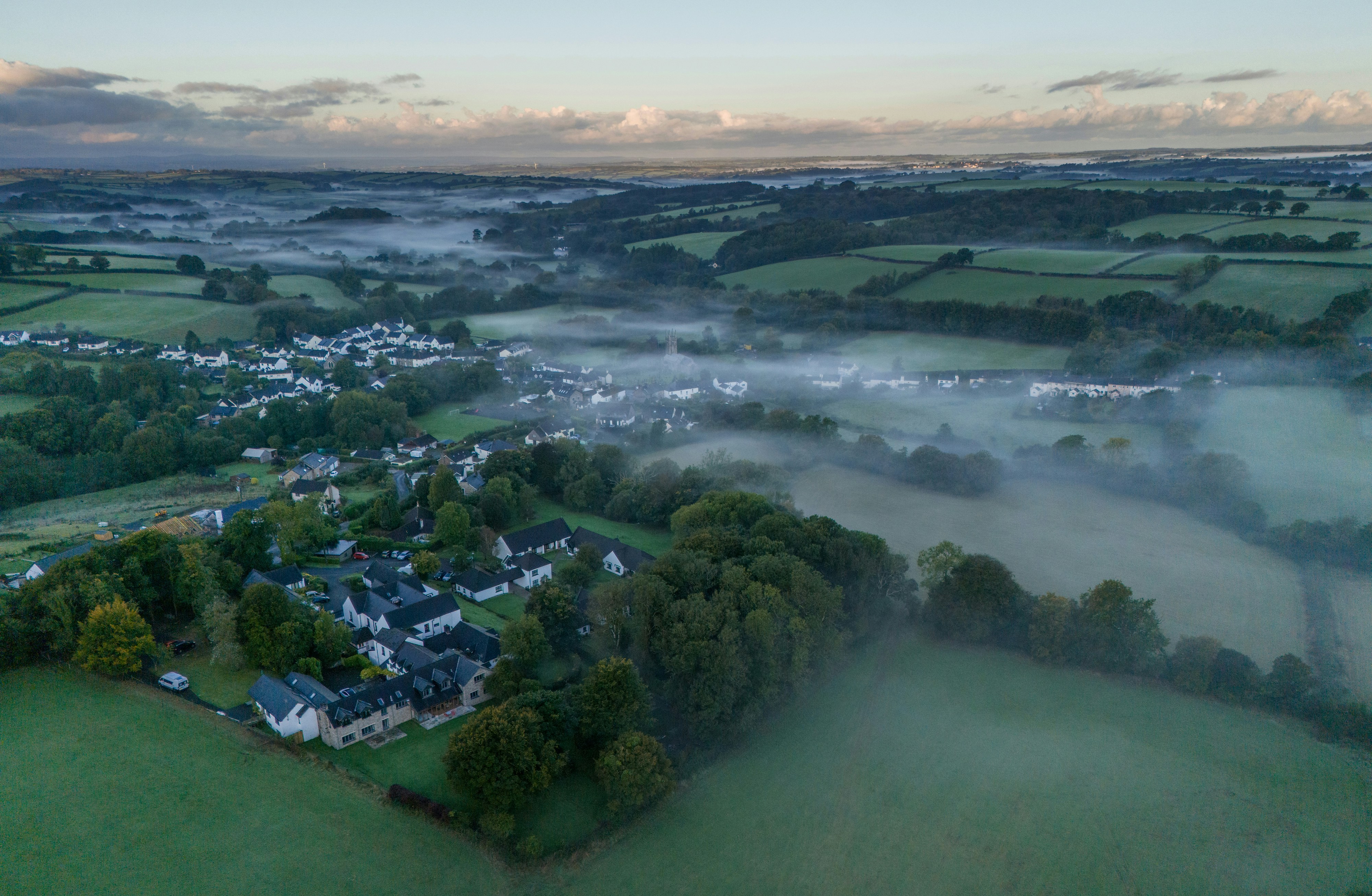 Mist Lapped Village: Aerial Quiet Over Rolling Farmlands