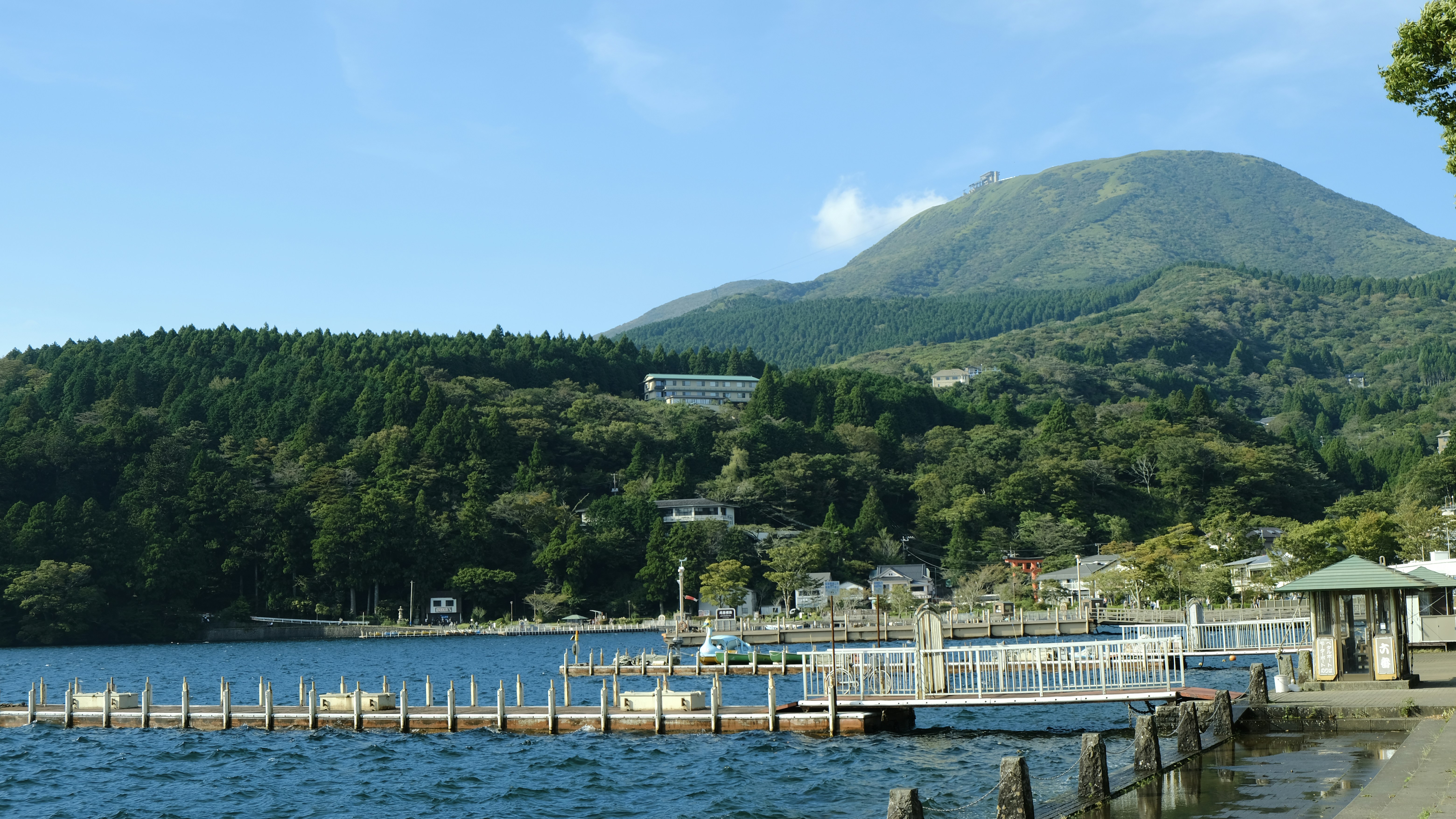 Quiet Lakefront Pier Framed by Forested Hills and a Distant Peak