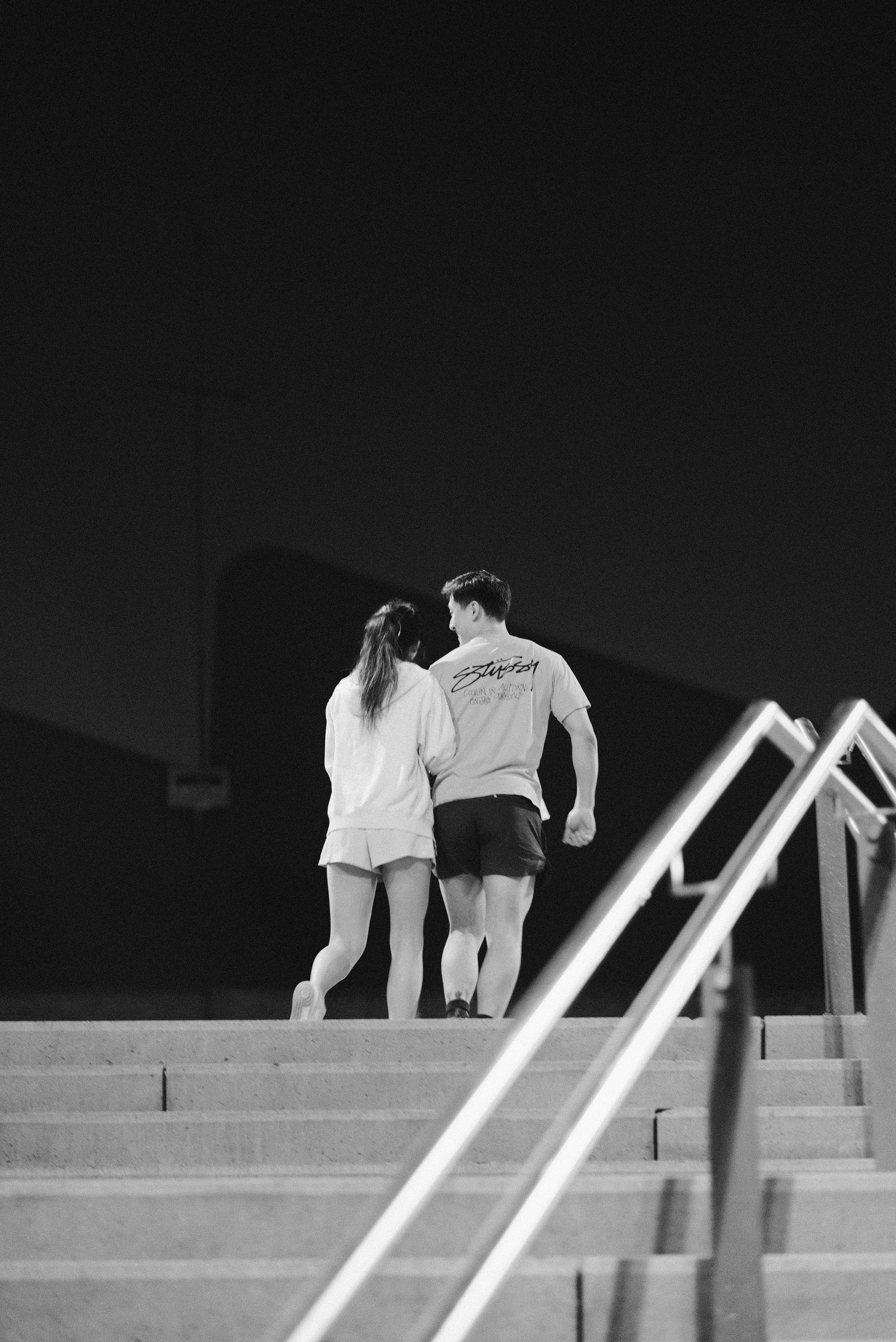 Quiet Ascent: A Nighttime Moment Between Two on the Stairs