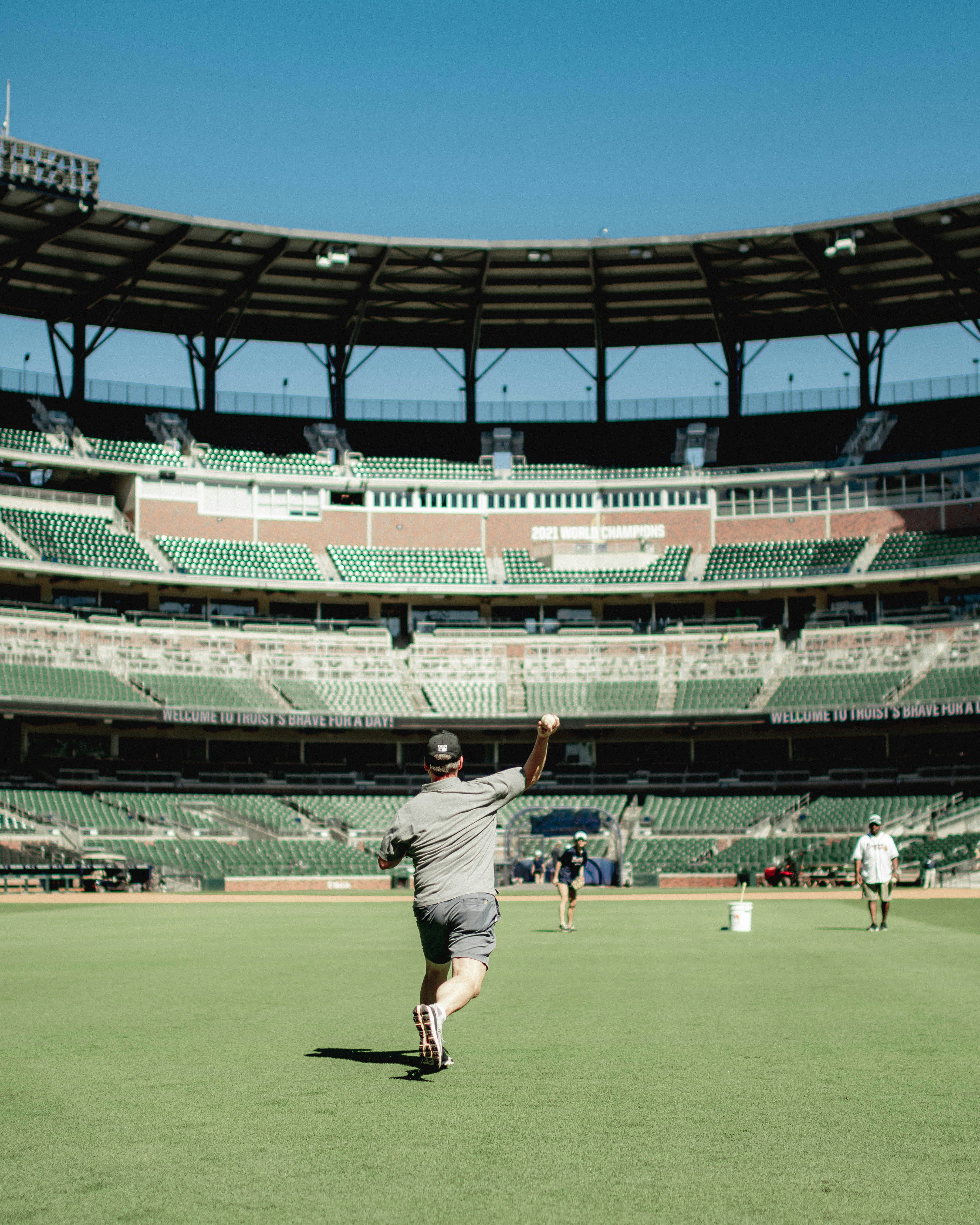 Solo Sprint Across a Quiet Ballpark Field Under a Clear Blue Sky