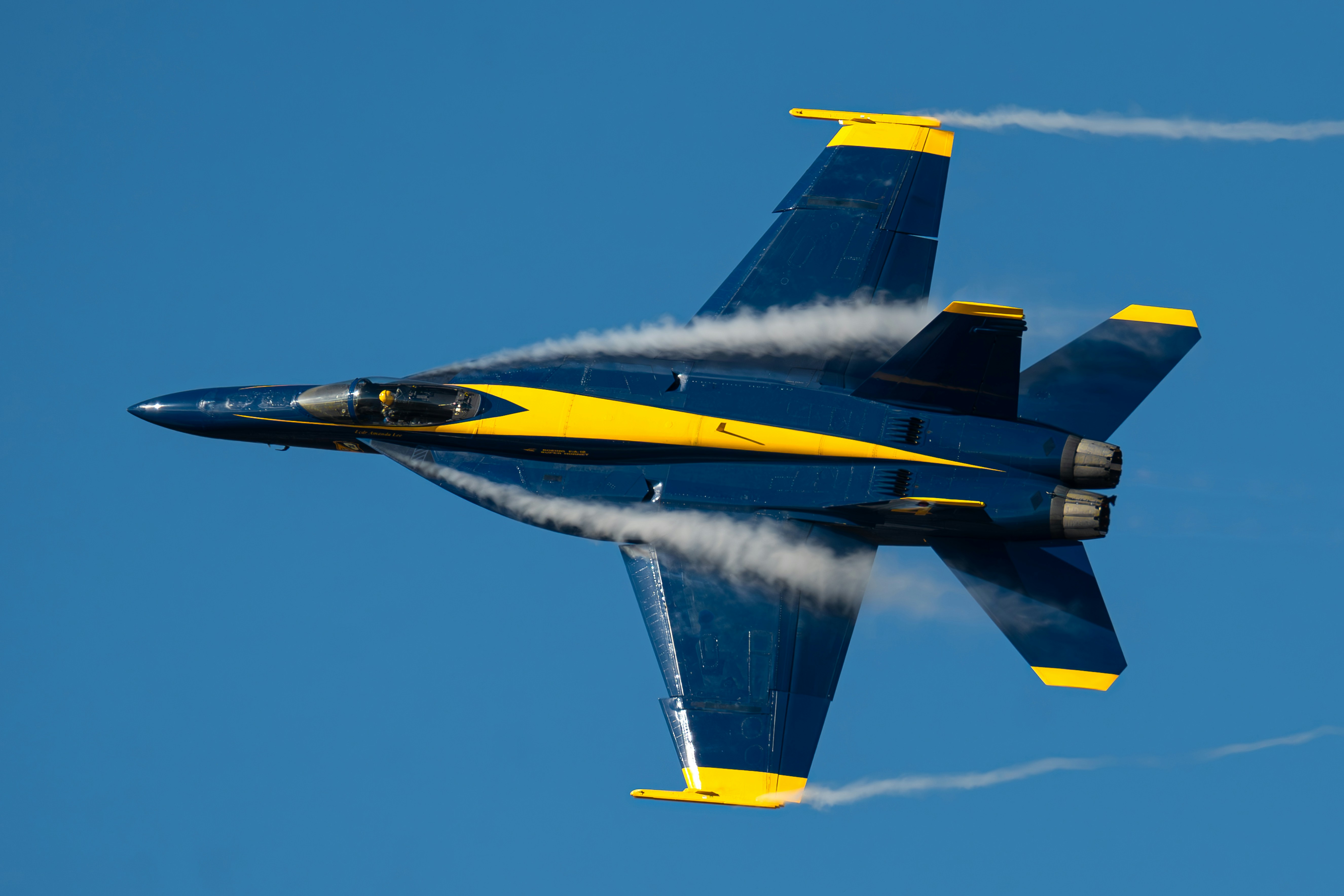 A blue and yellow jet flying through a blue sky photo – Free Mcas ...