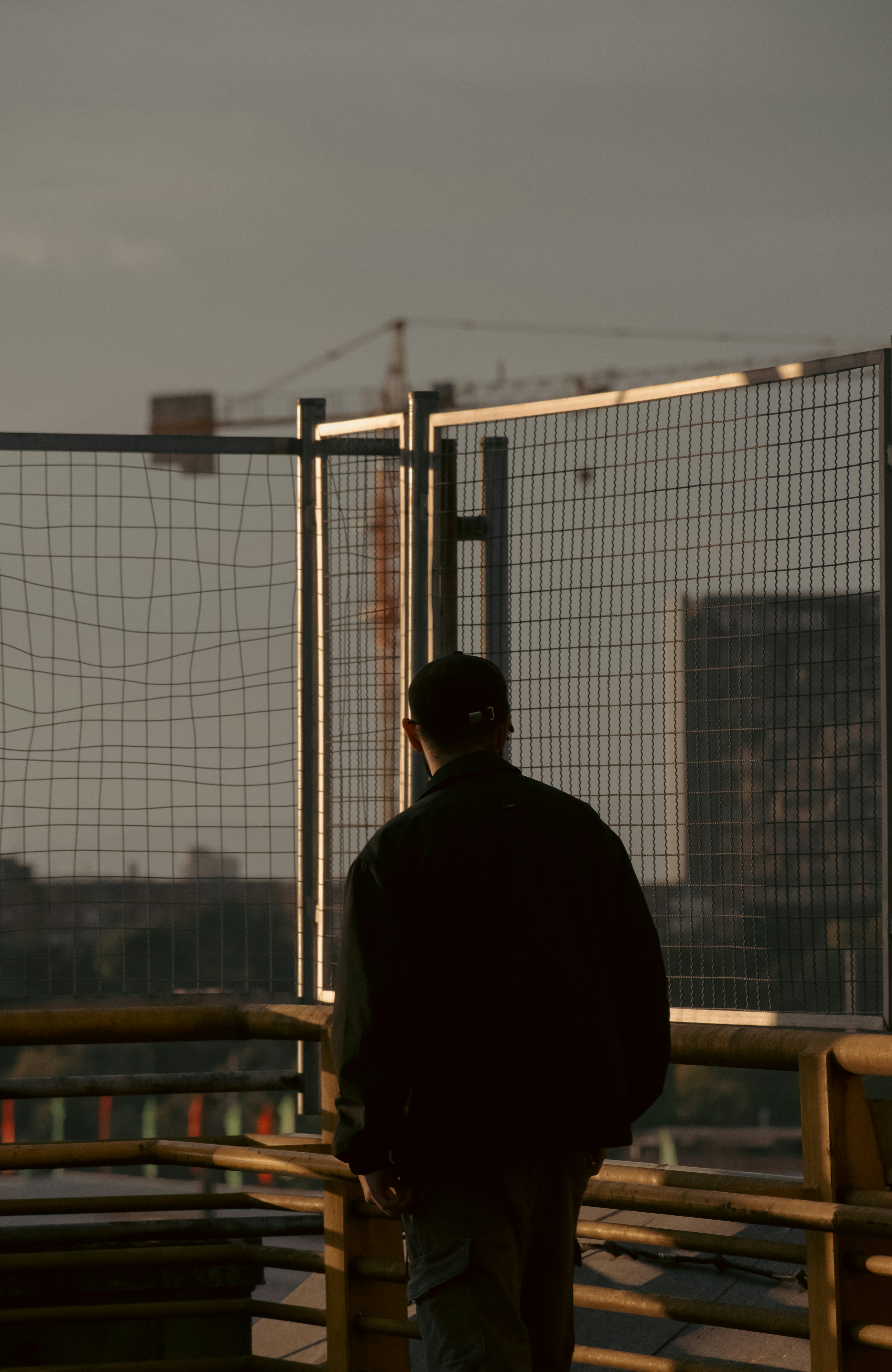 A man standing on top of a bridge next to a tall building photo – Free ...