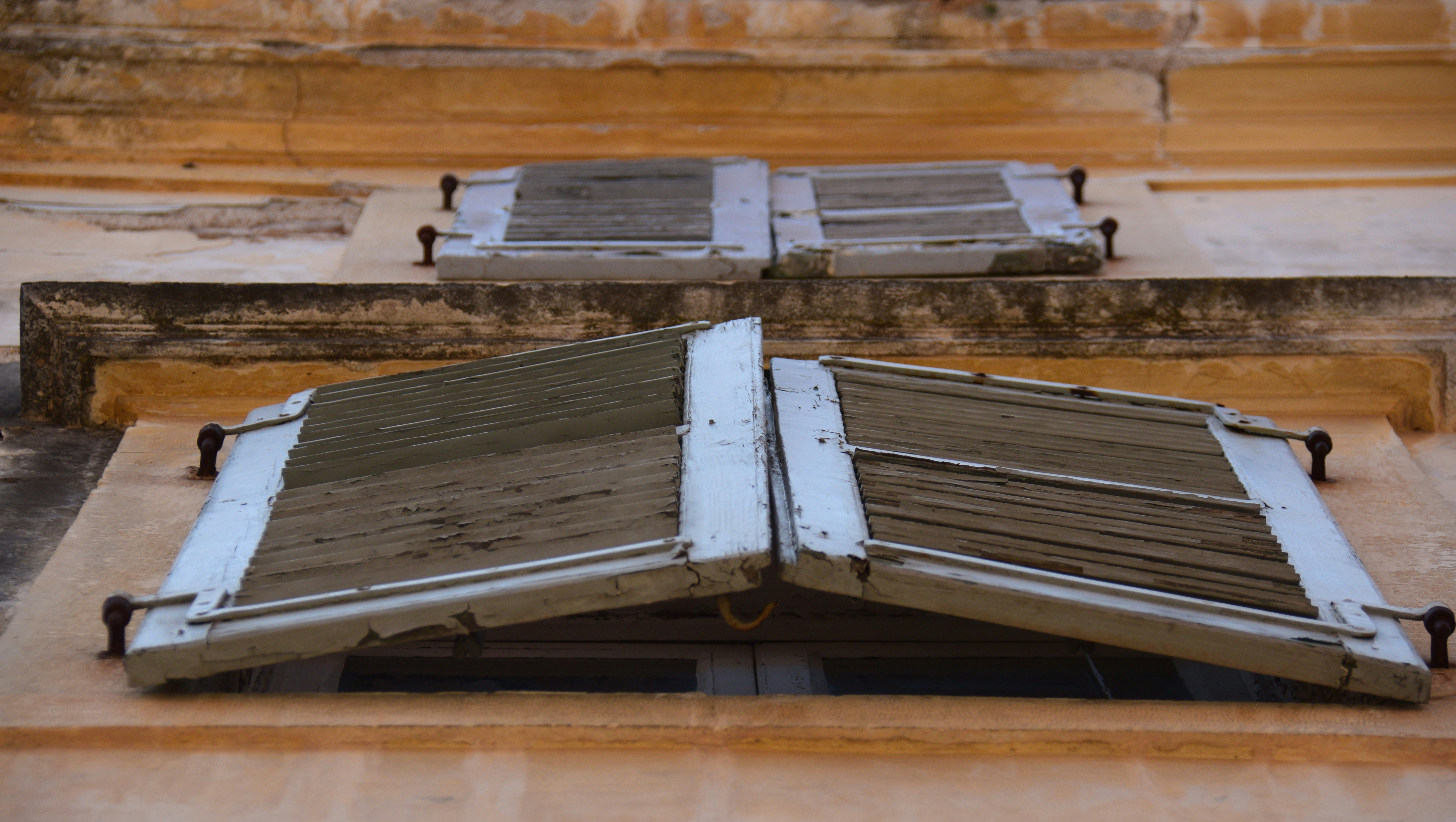 Tilted Shutter Chorus on a Sun-Warmed Facade
