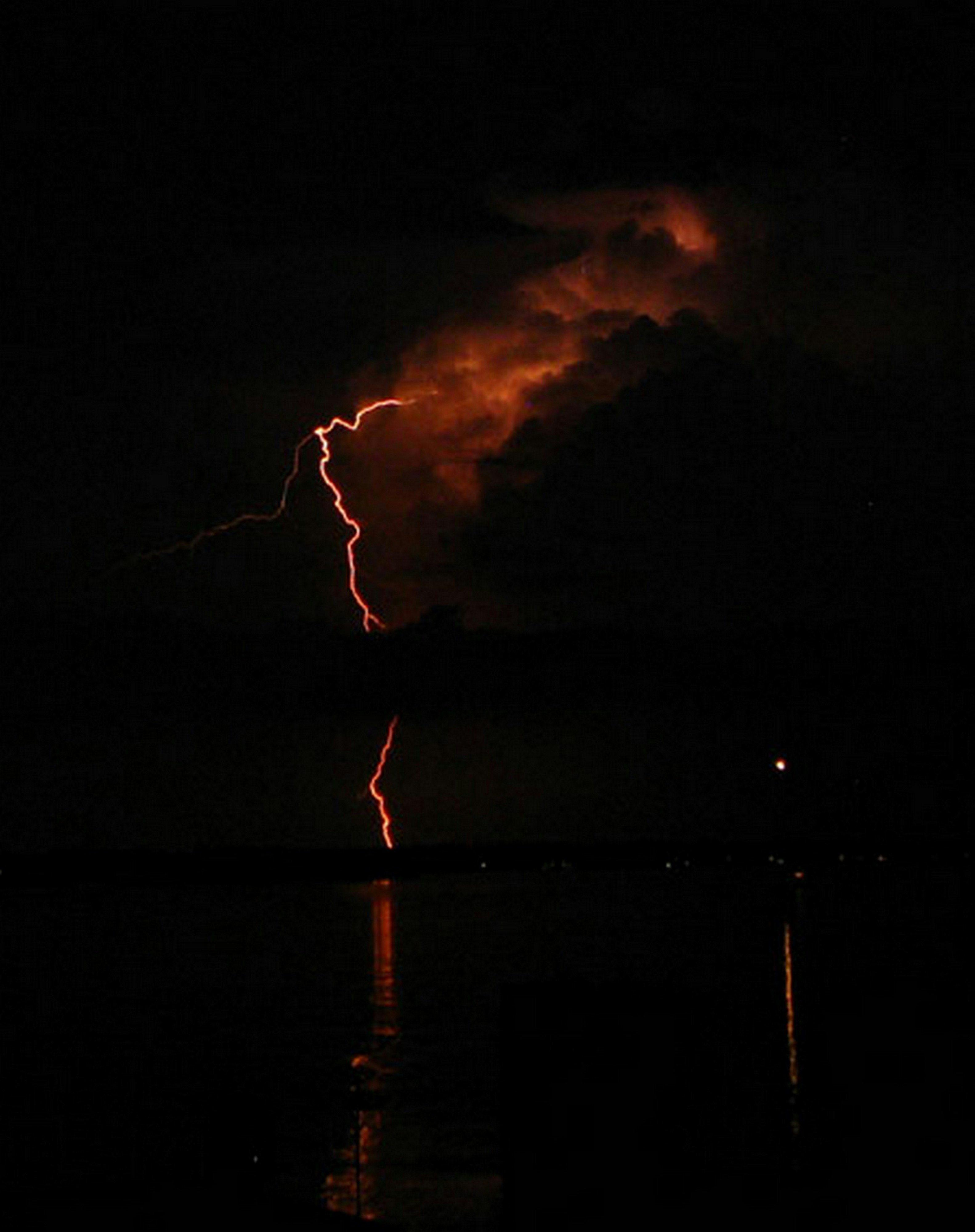A lightning is seen in the sky over the water photo – Free Weather ...